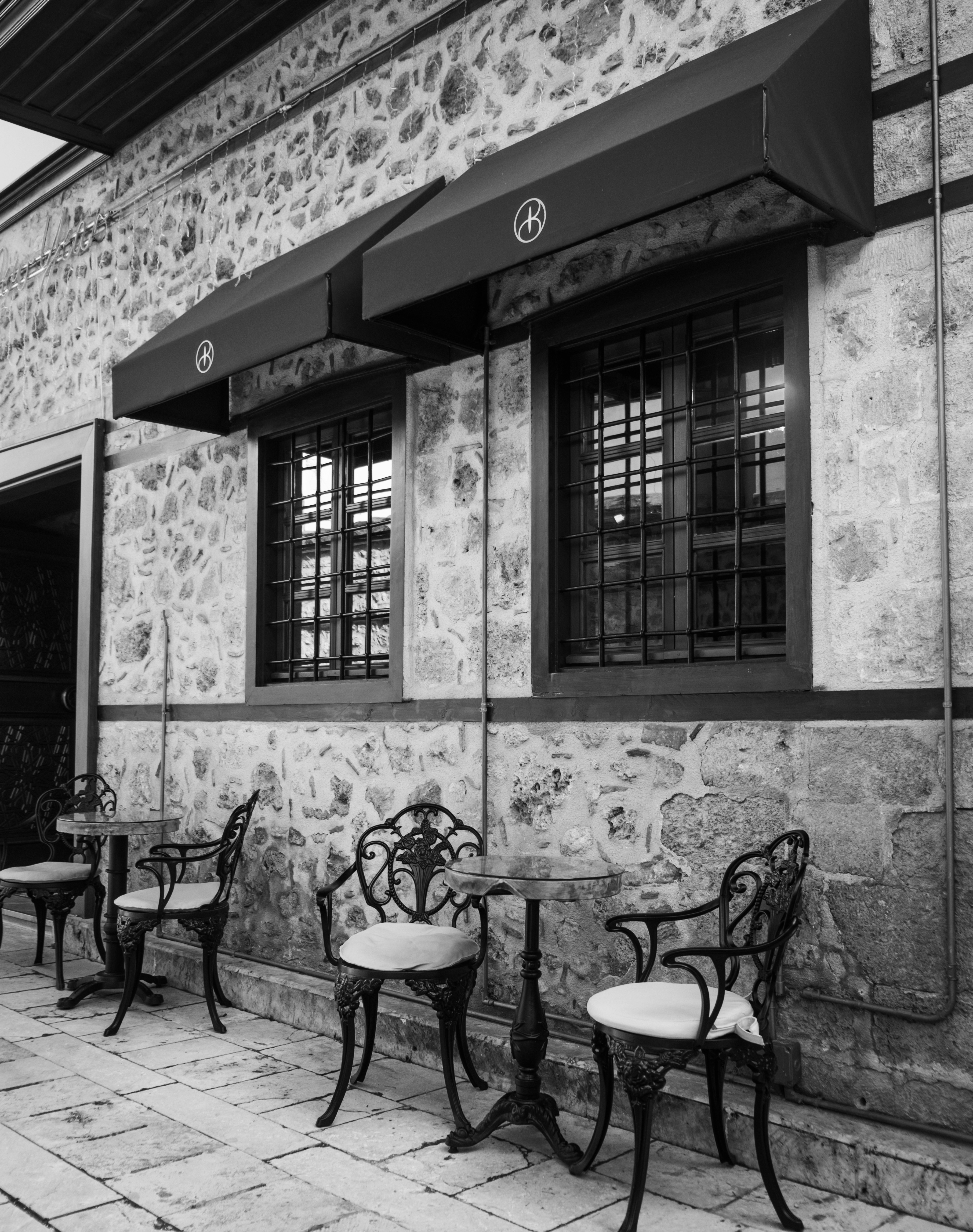 Stone Café Quiet Presences: Outdoor Chairs By a Walled Window