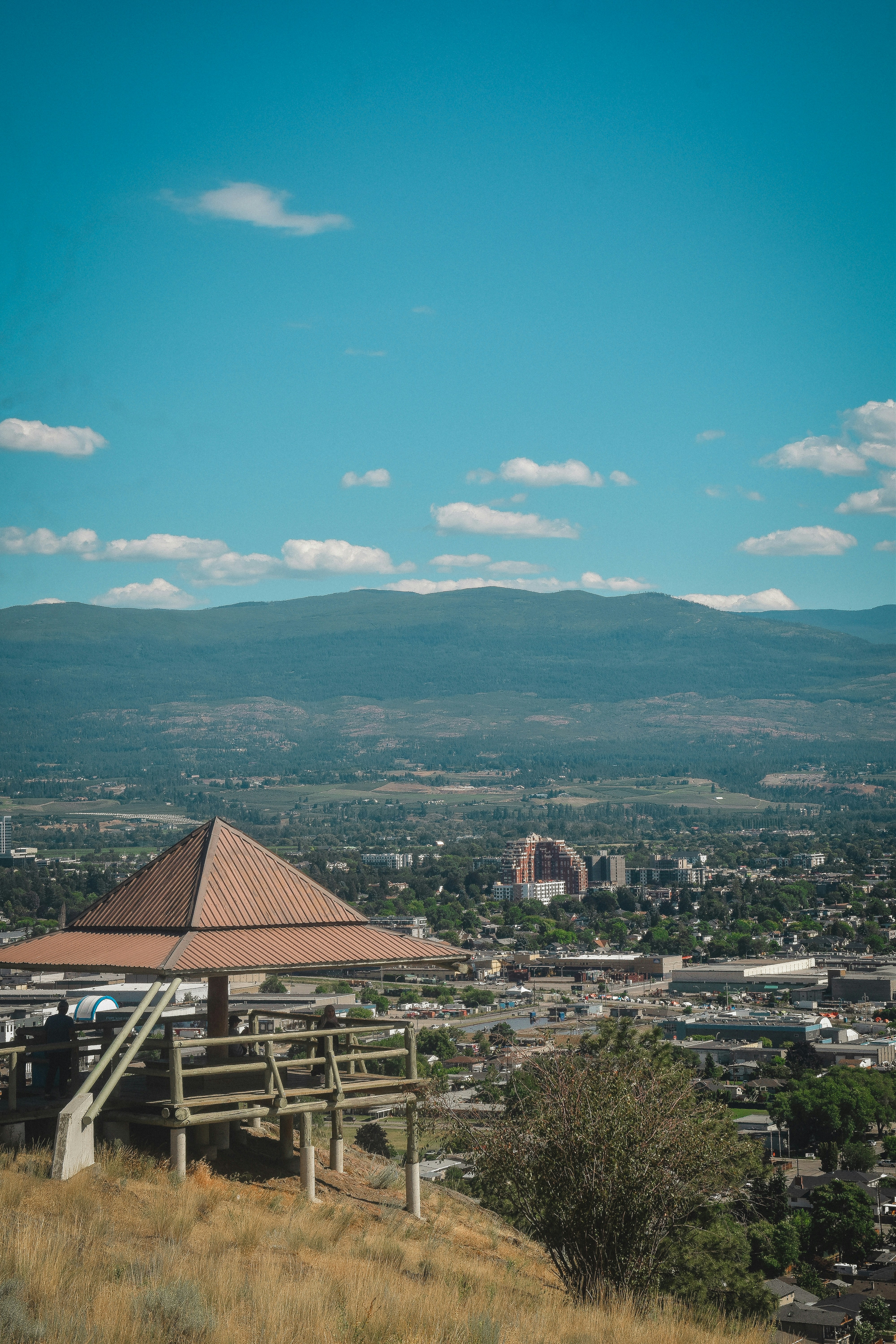 Hilltop Shelter Overlooking a Cityscape Beneath a Wide Blue Sky
