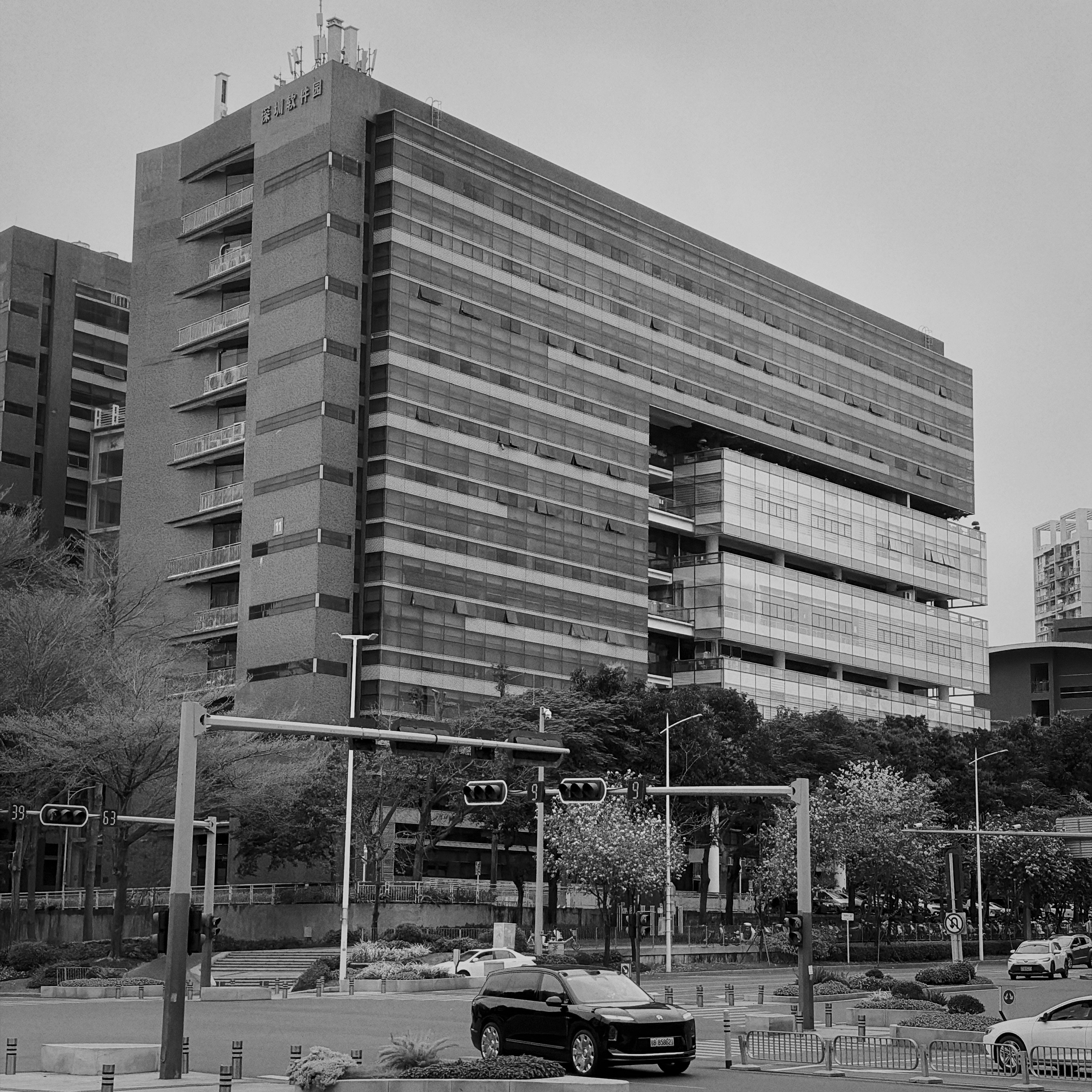 Modern office building with glass facade and cars on street