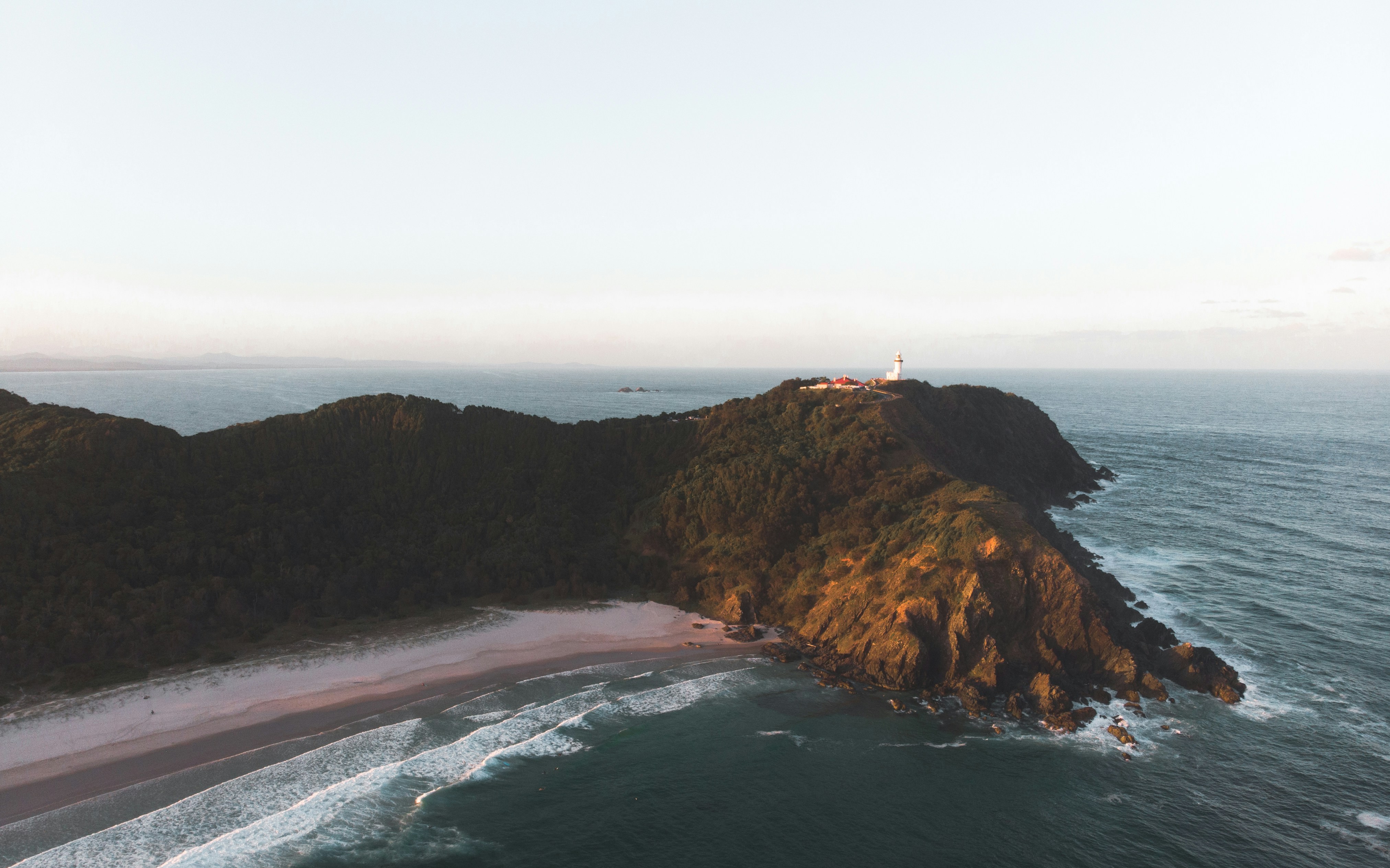 Lighthouse Crest: Sunset Over a Rugged Coastal Headland