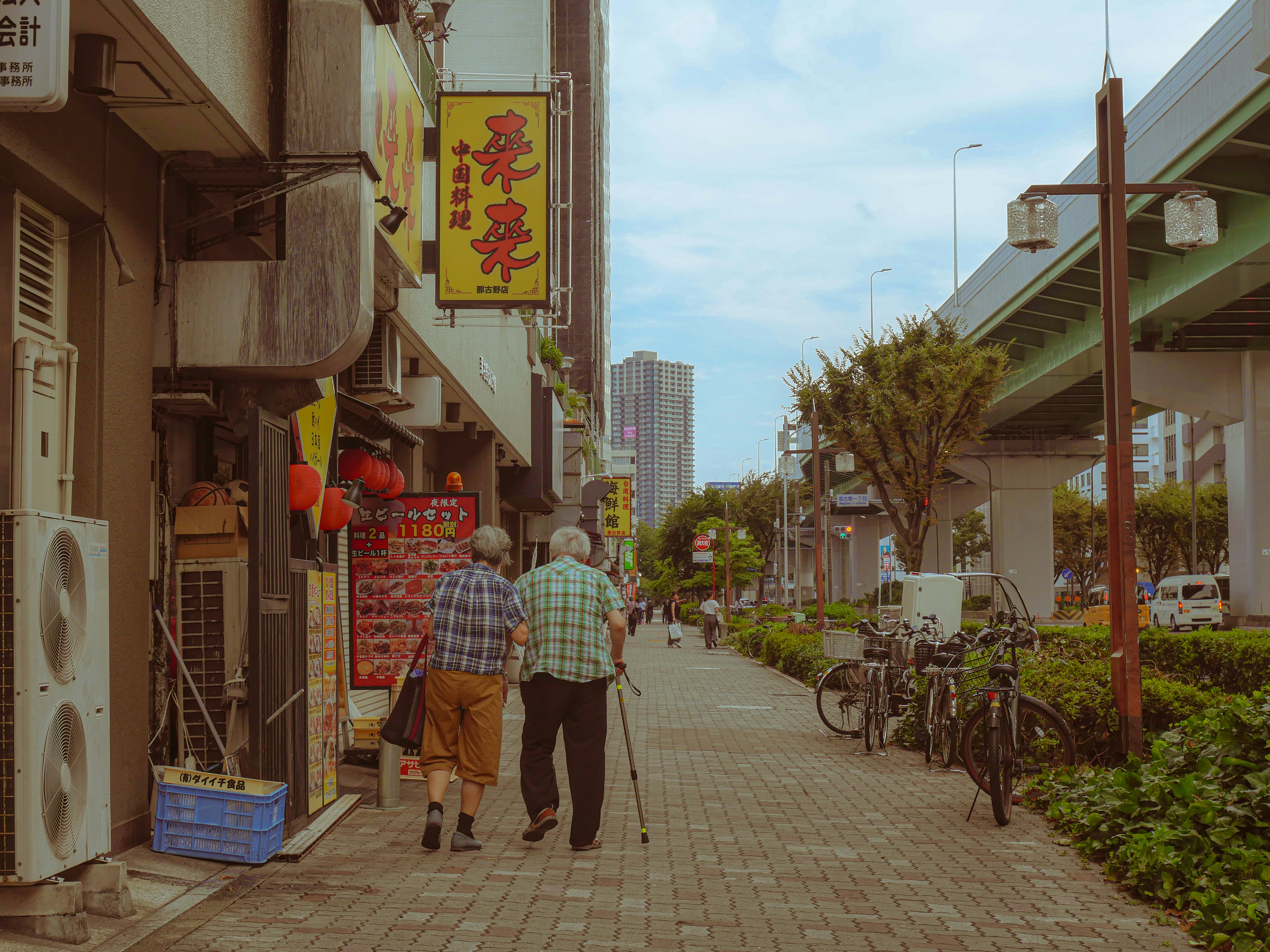 Crossing Paths: Elderly Walkers On a Sunlit City Alley