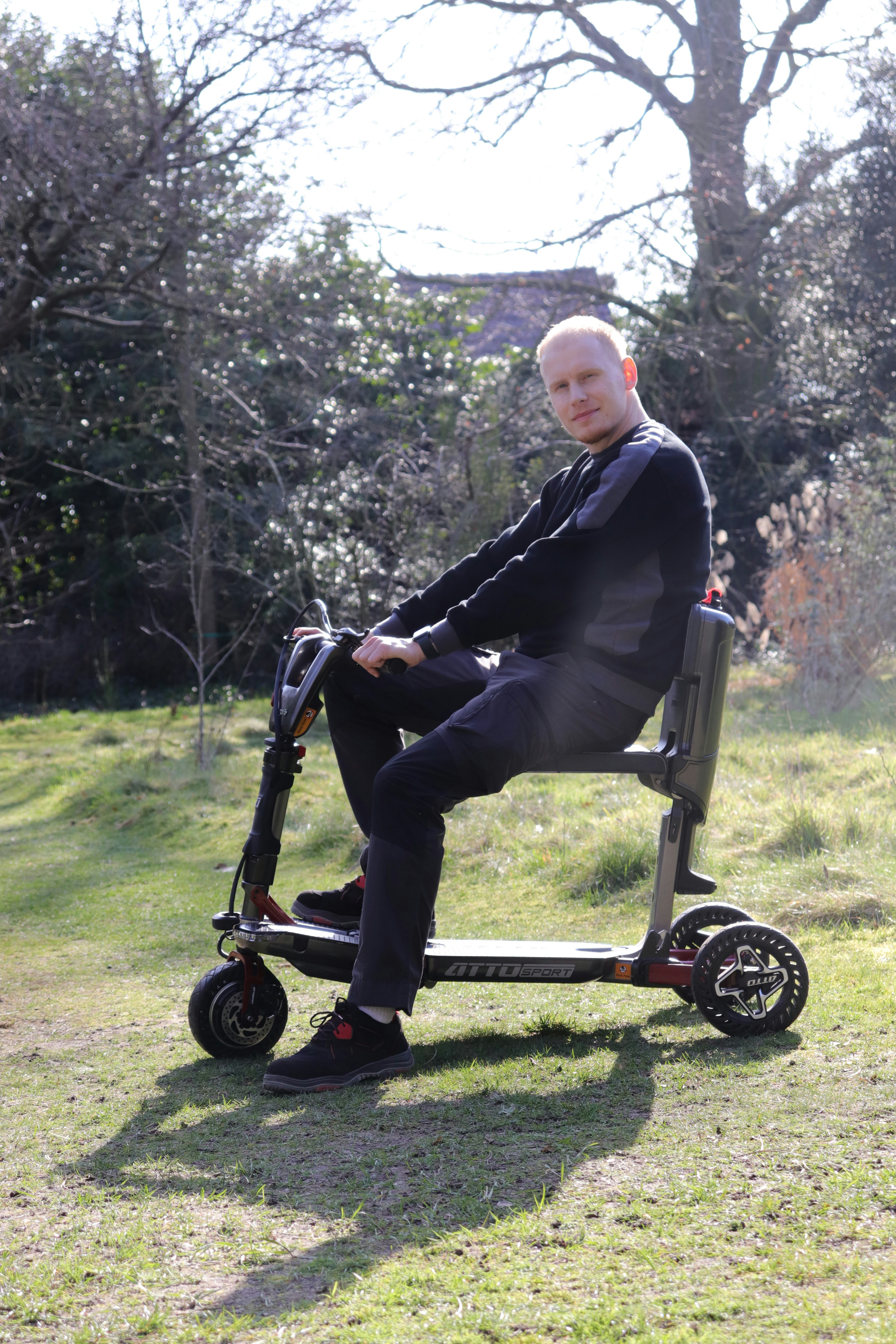 Rider in a compact electric scooter carves a sunlit moment in the park