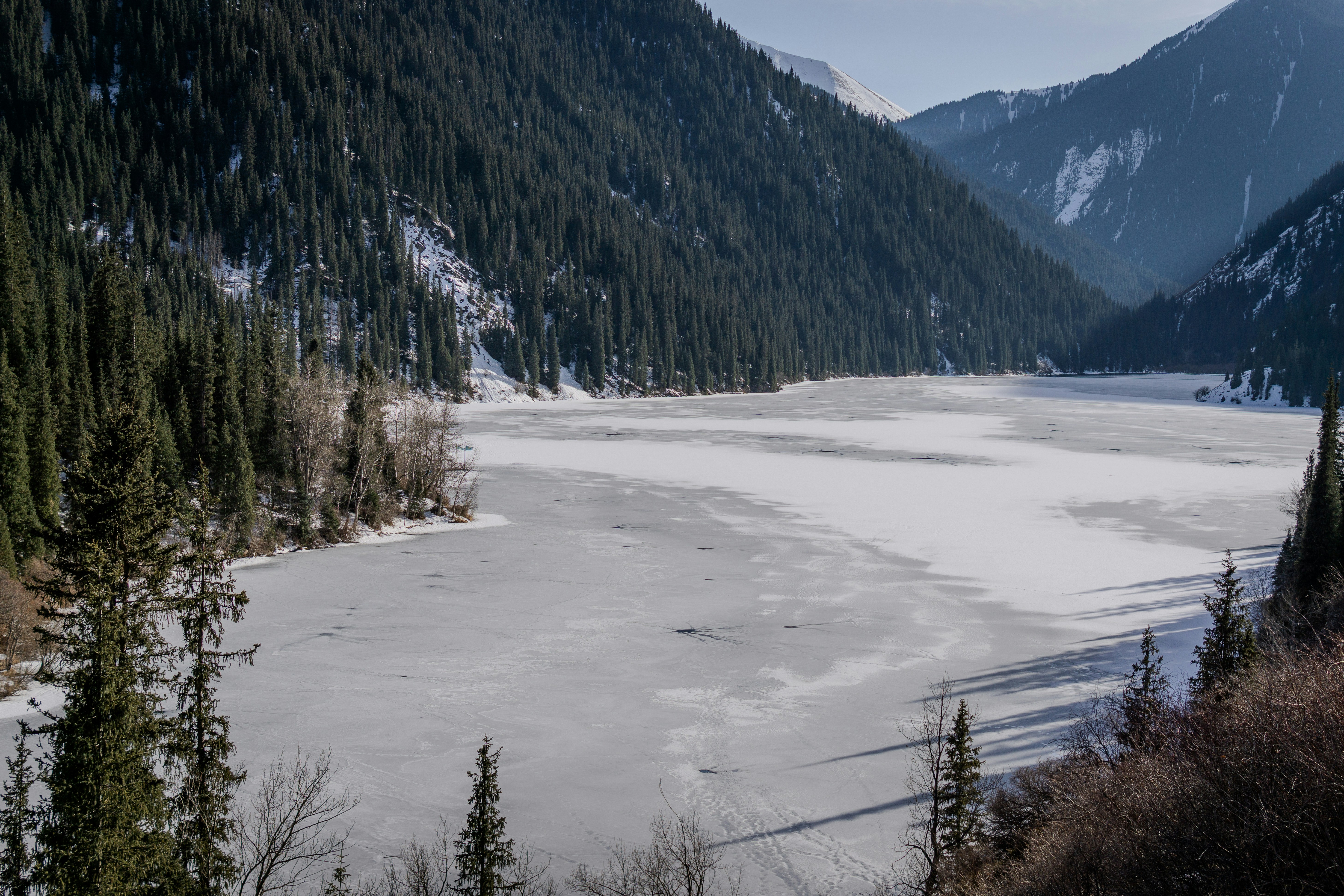 Frozen Fjord: A Snow-Covered Lake Between Mountain Walls
