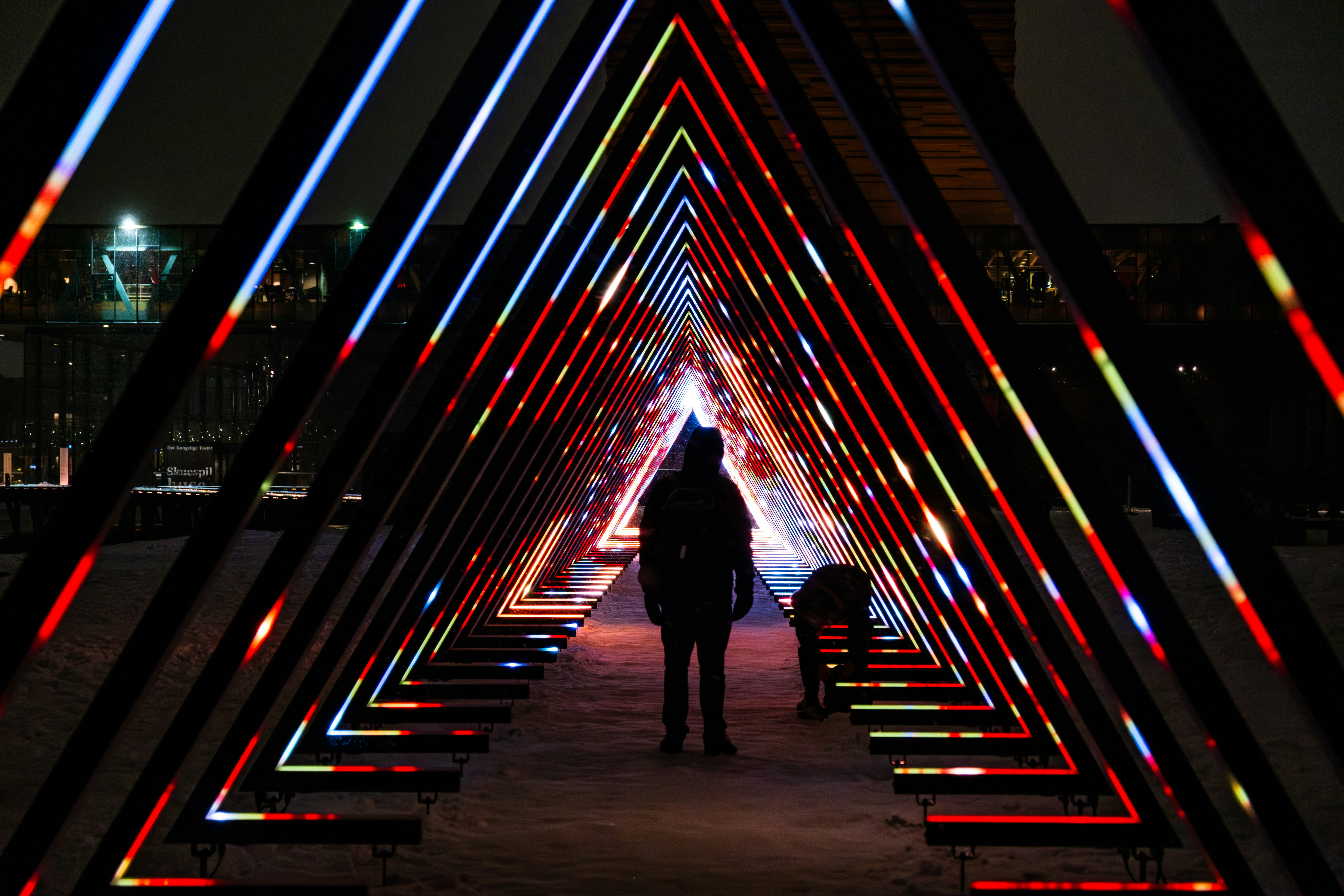 Neon Triangles: A Lone Wanderer Walks the Light Corridor