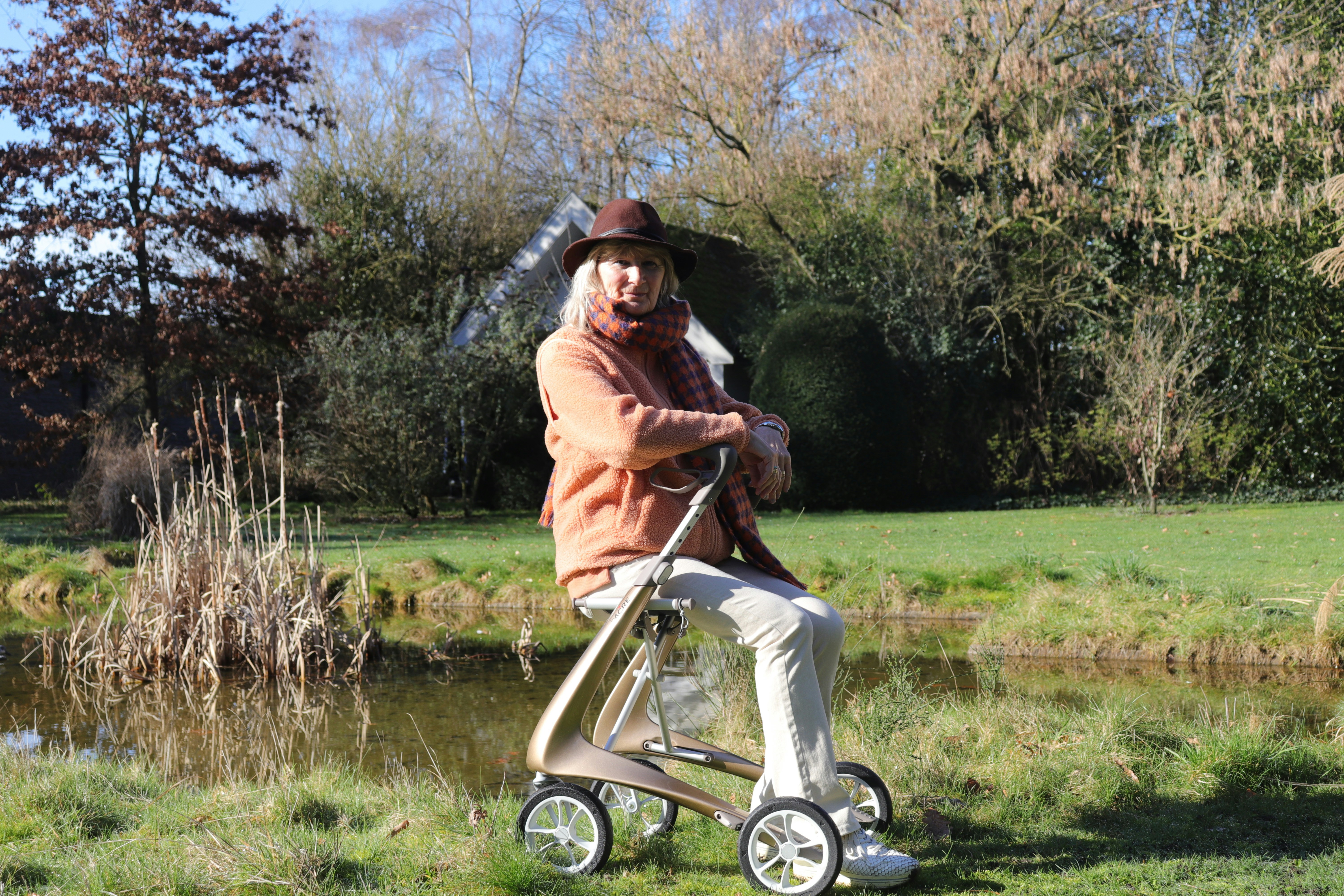 Elderly Traveler in a Vintage Glider Cart Amid Open Park