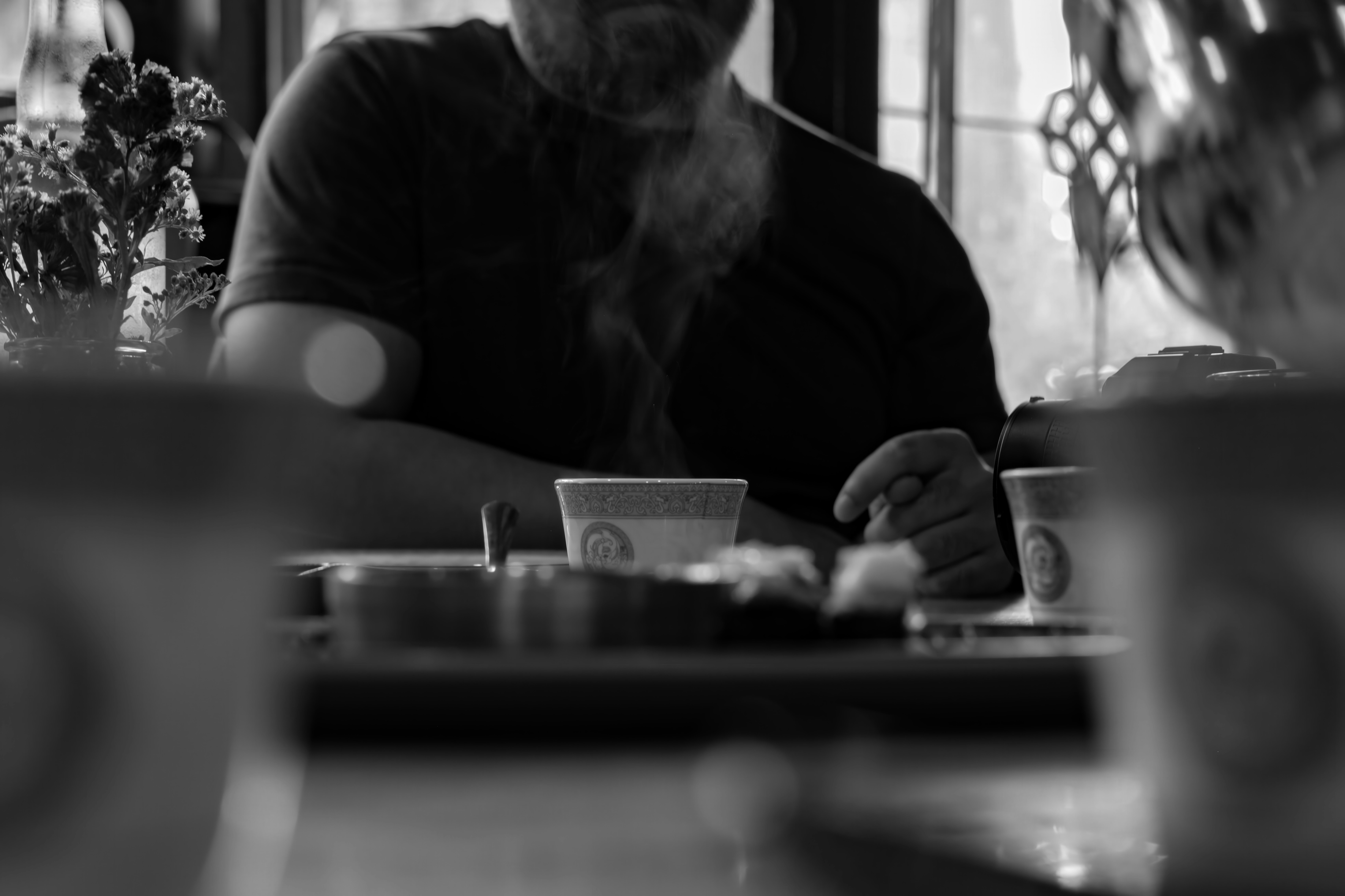 Quiet Gathering: A Blurred Tabletop Moment in Monochrome