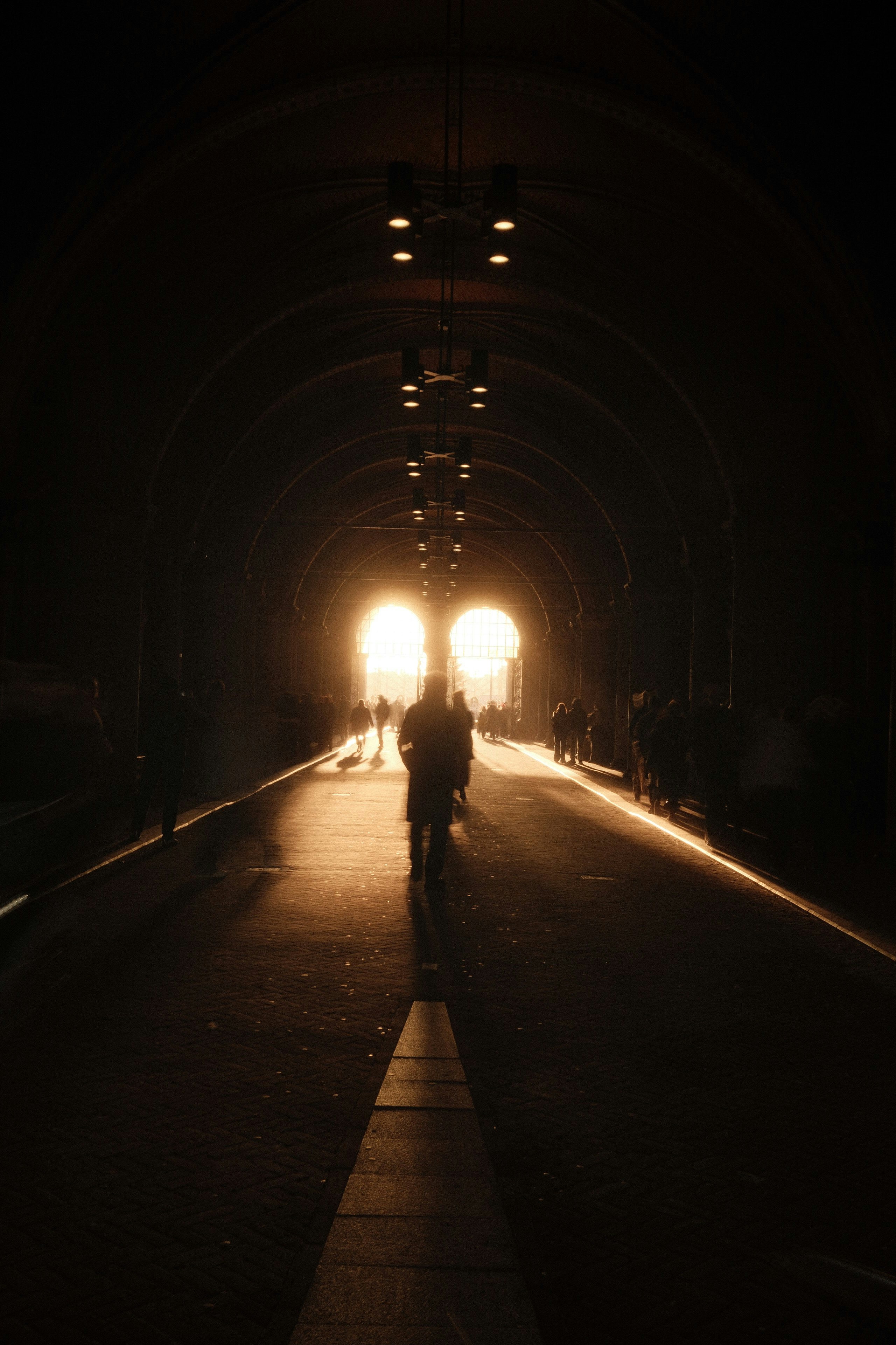Glow at the Tunnel Exit: A Silhouetted Walk Toward Light