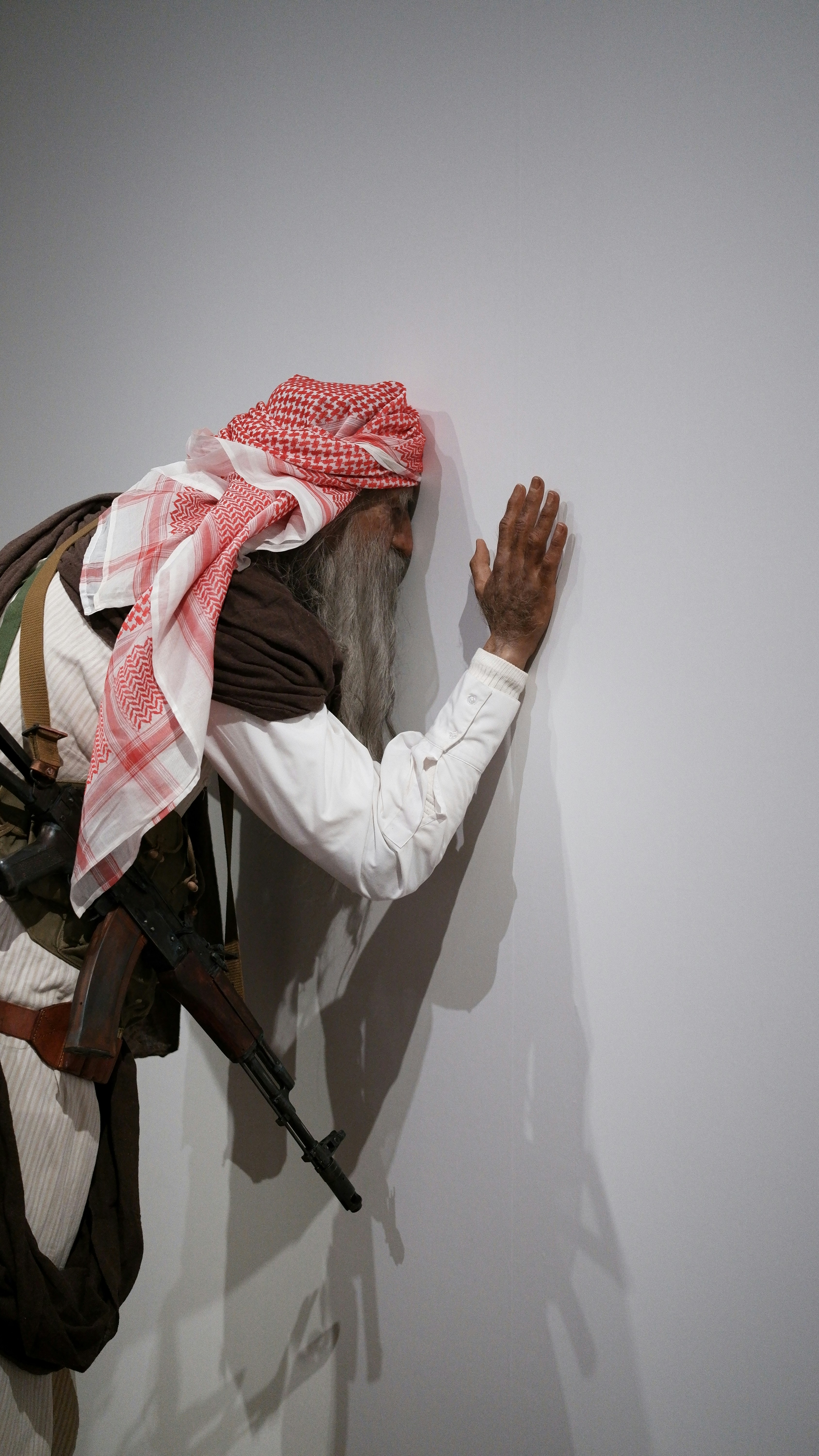 Ancient Traveler Pressed Against a White Wall