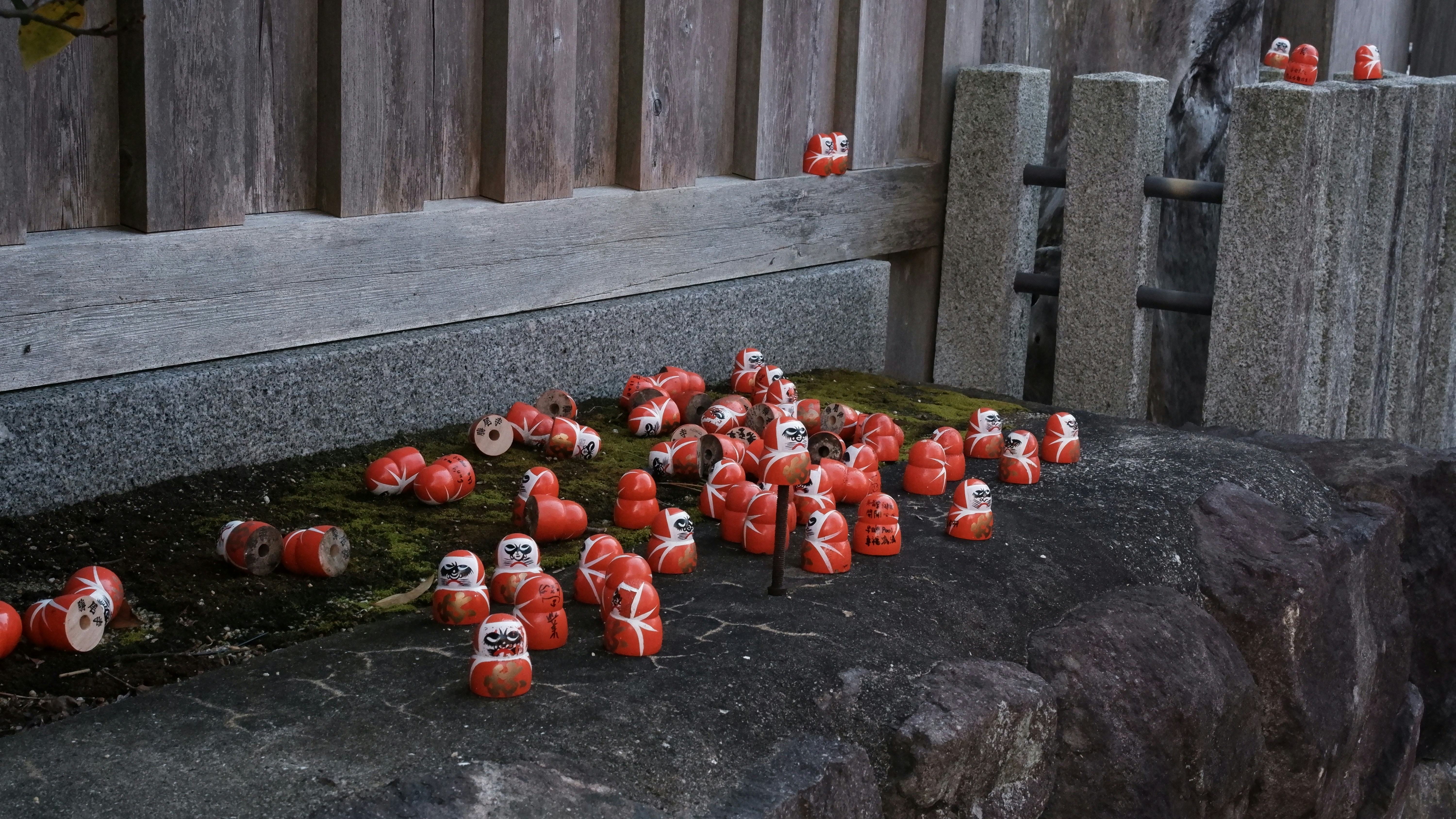 Red Daruma Parade along a Weathered Wall