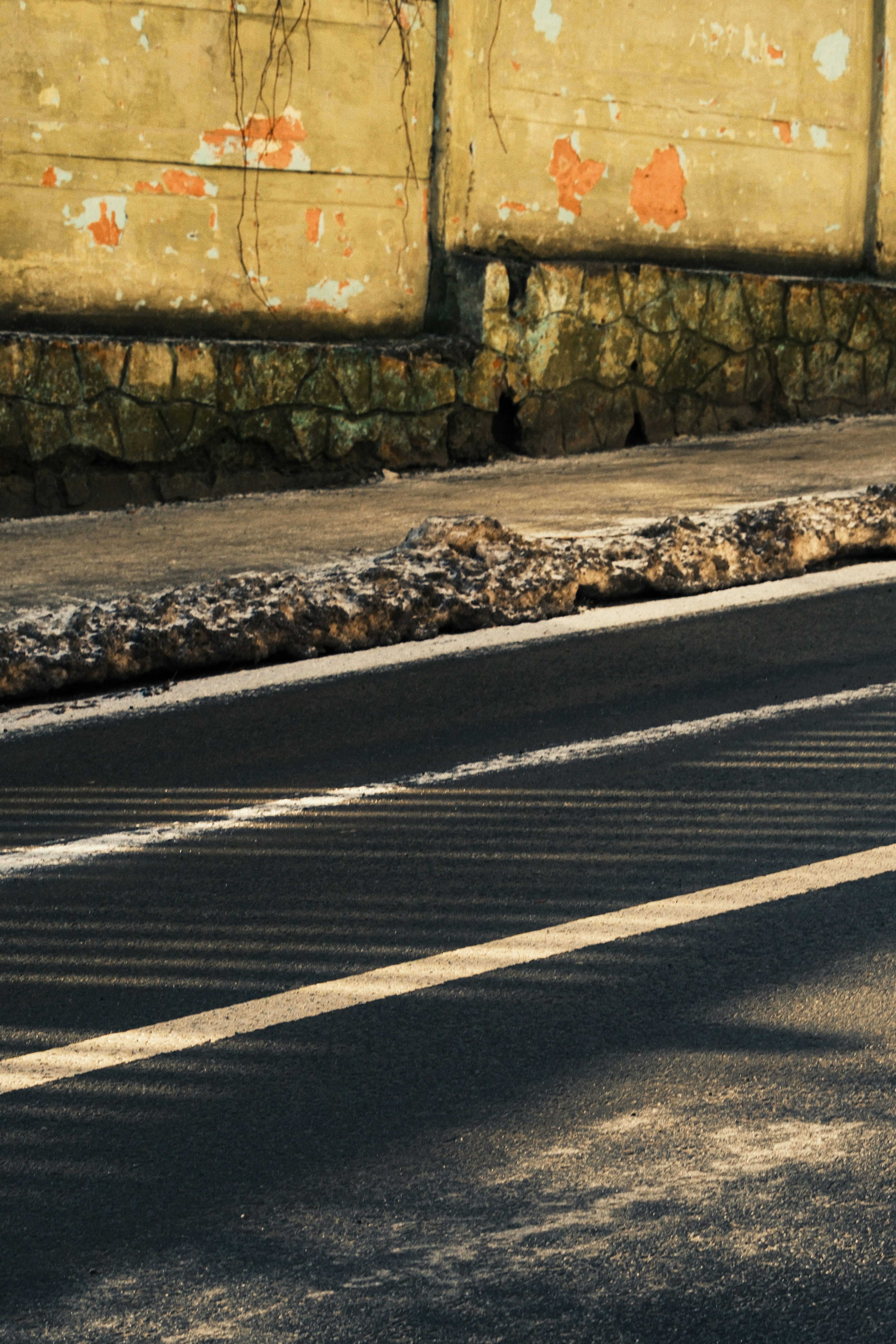 Cracked Wall and Sunlit Street Edge