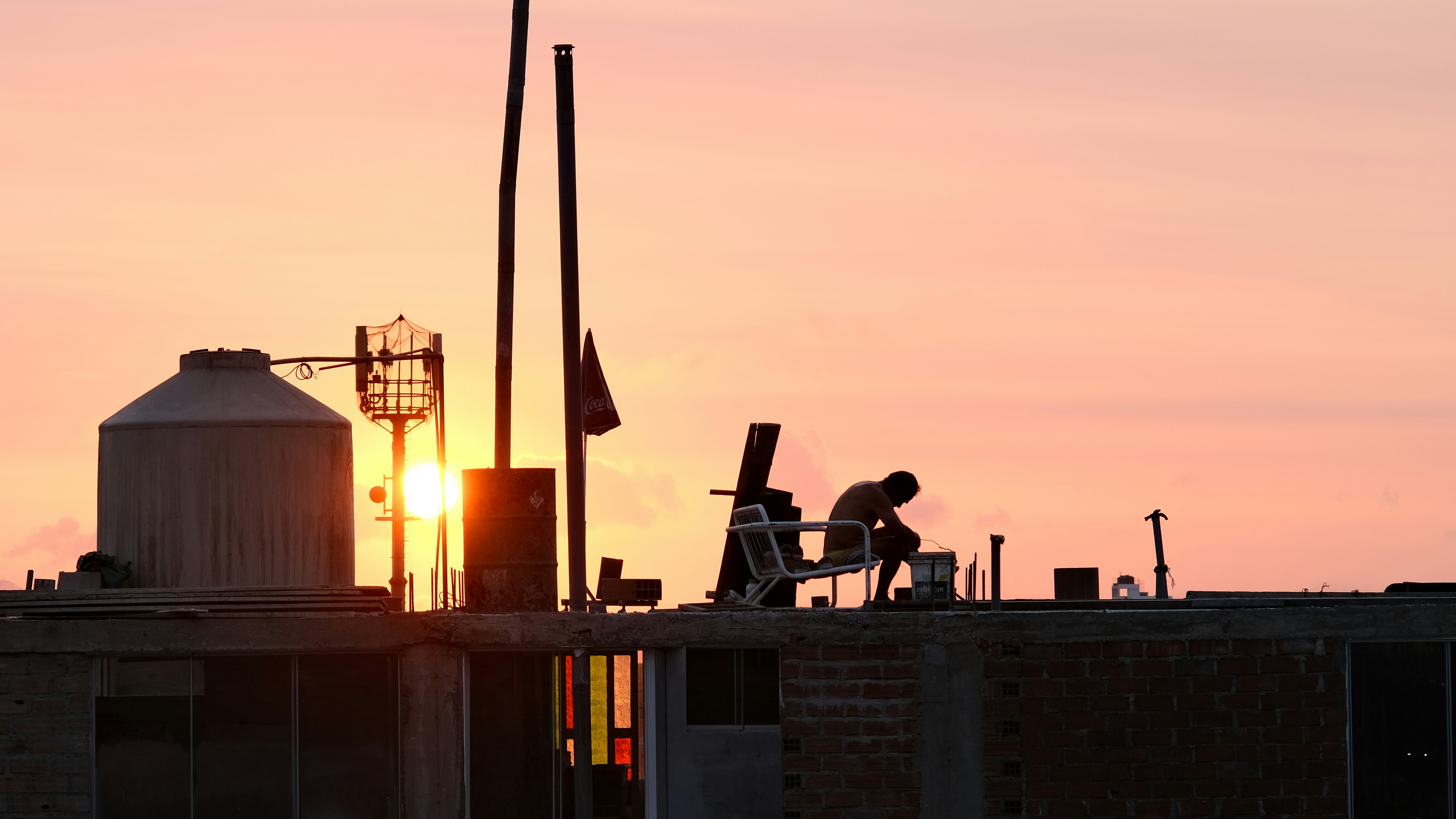 Sunlit Rooftop Quiet: A Worker at Dusk