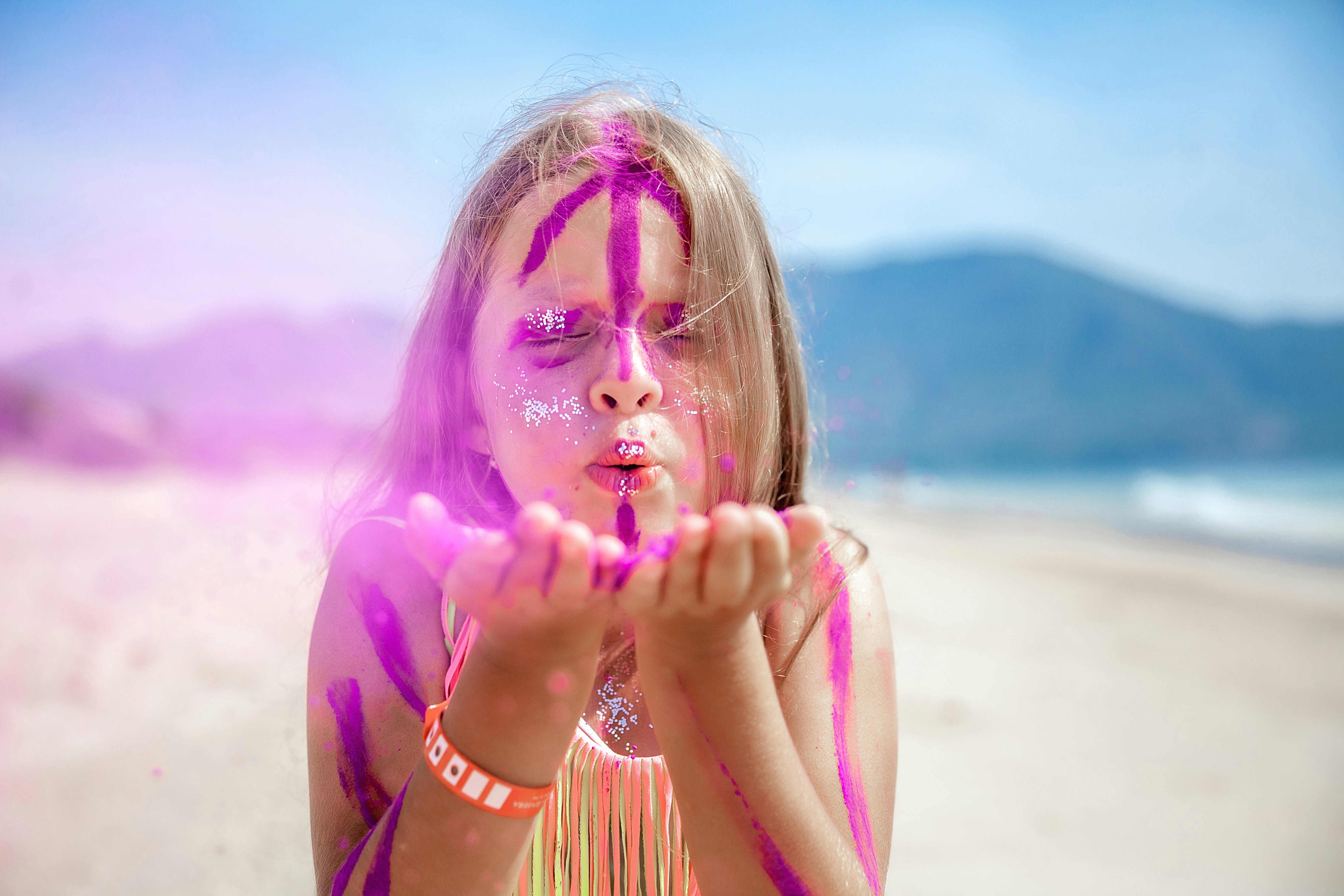 Confetti of Color: A Girl Blows Painted Light on the Beach
