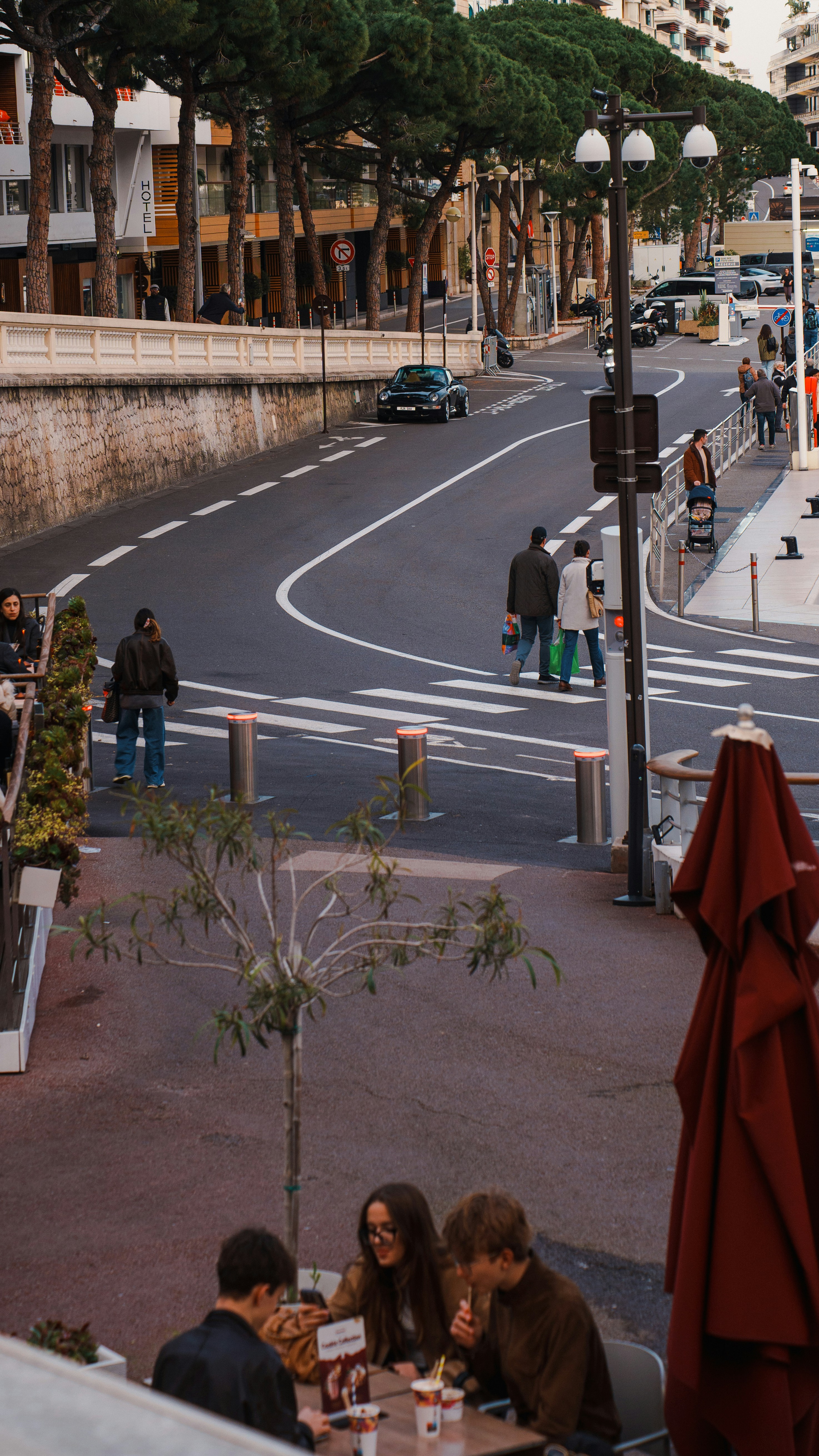 Lively Mediterranean Street Scene with Pedestrians and Curbside Café