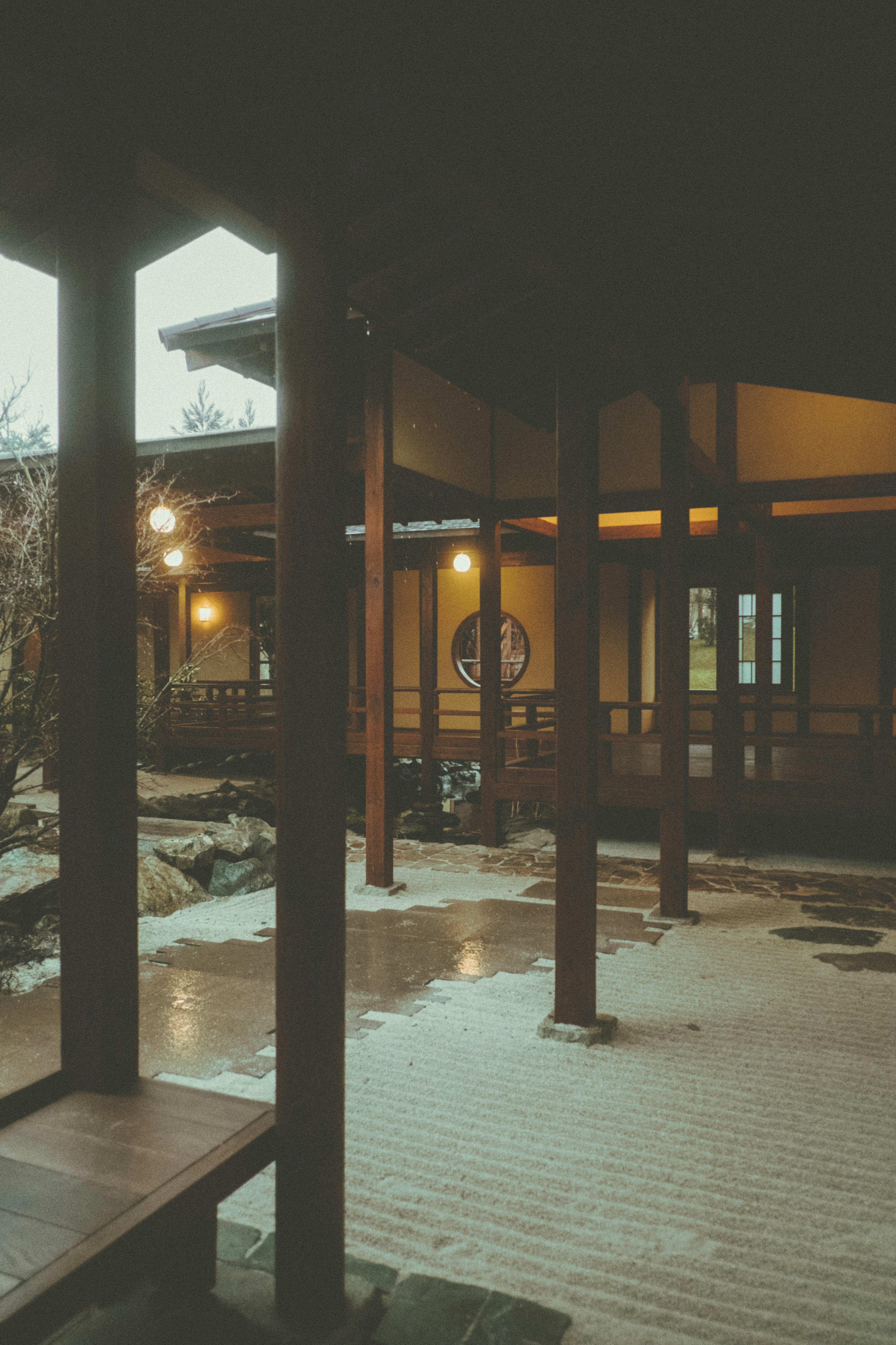 Warm Lanterns Beneath Wooden Beams in Quiet Courtyard