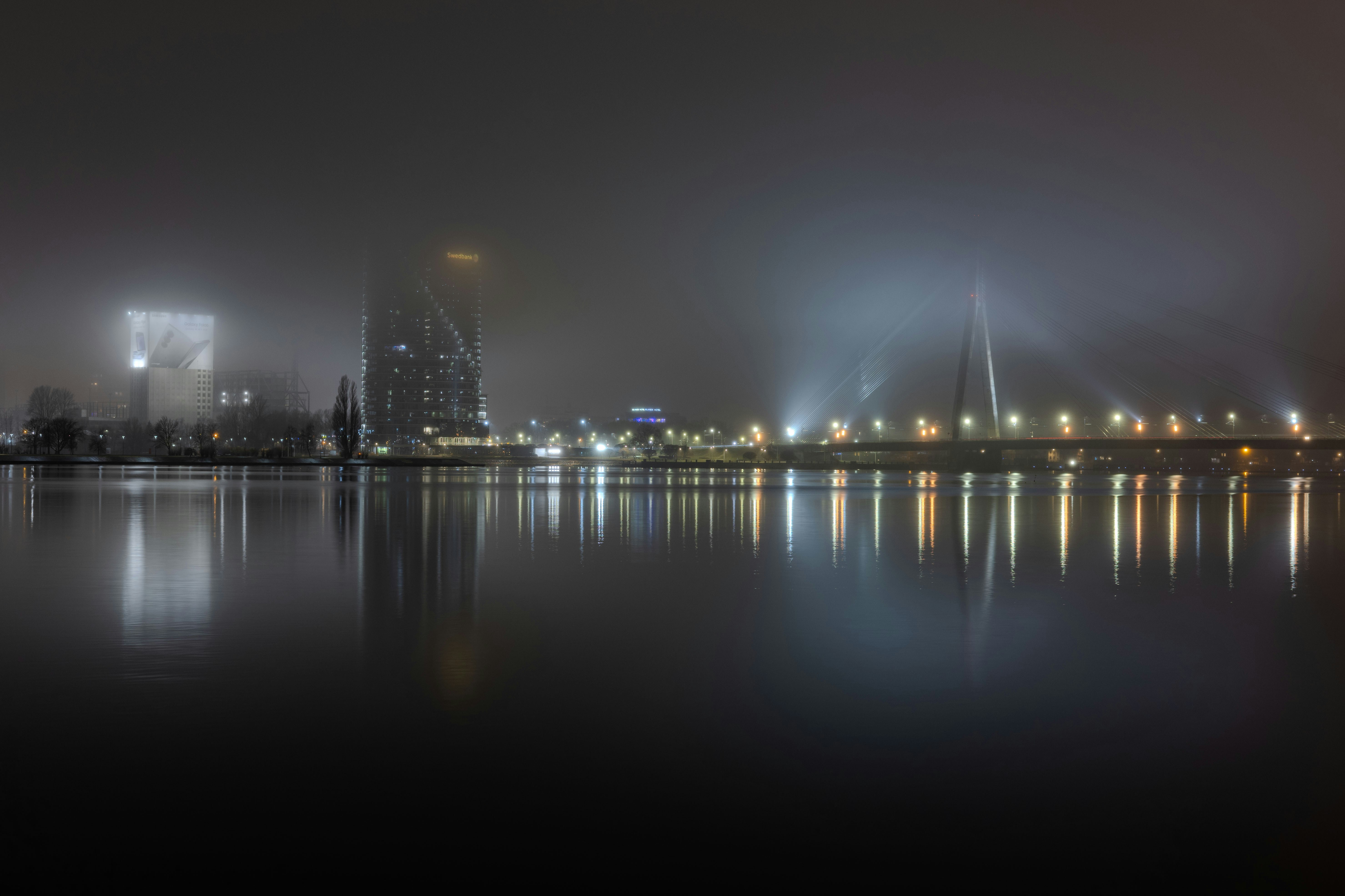 Mist over the Riverfront: Neon Reflections at Dusk