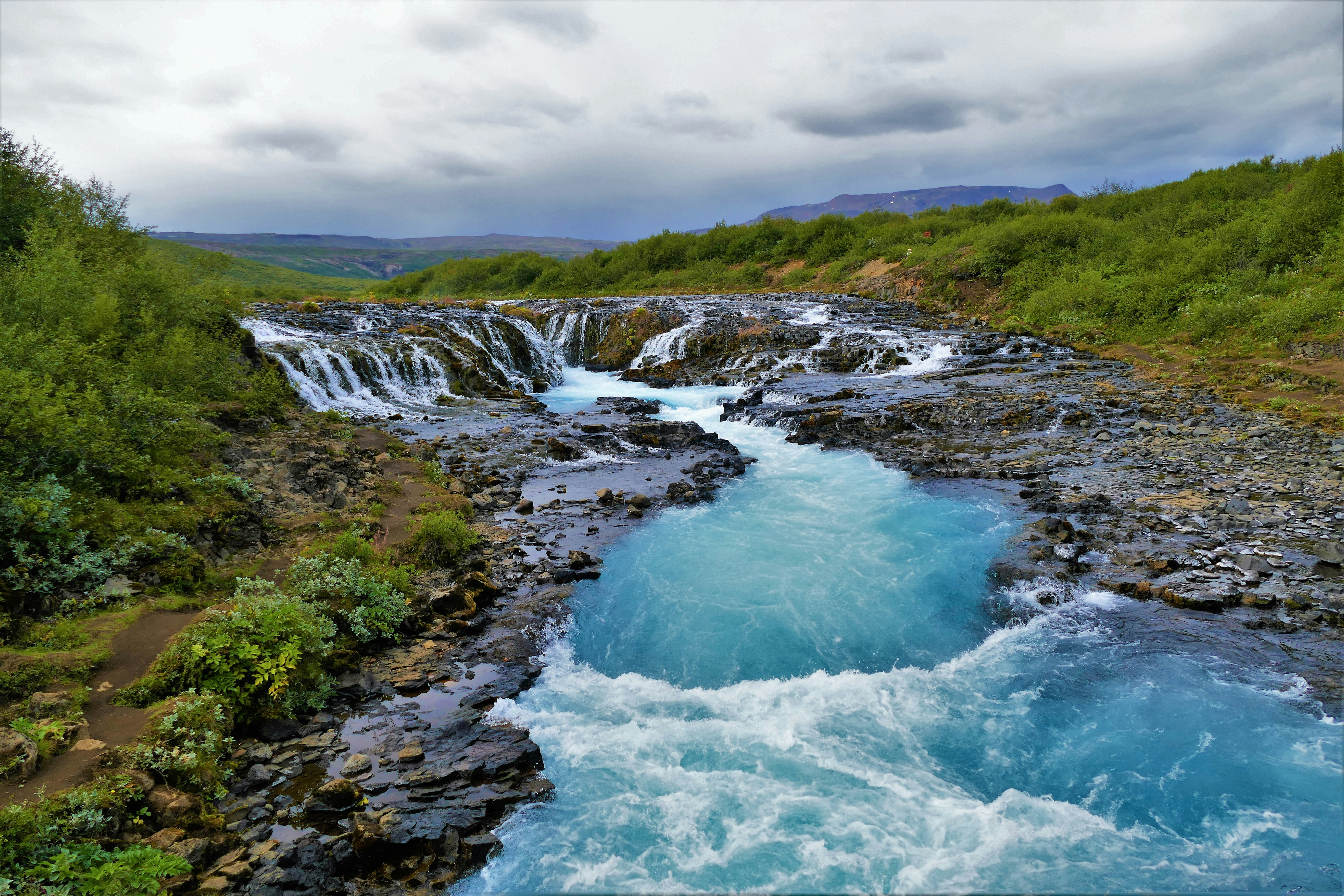 Turquoise Cascade: Steam-Chasmed River Carving Blue Lanterns
