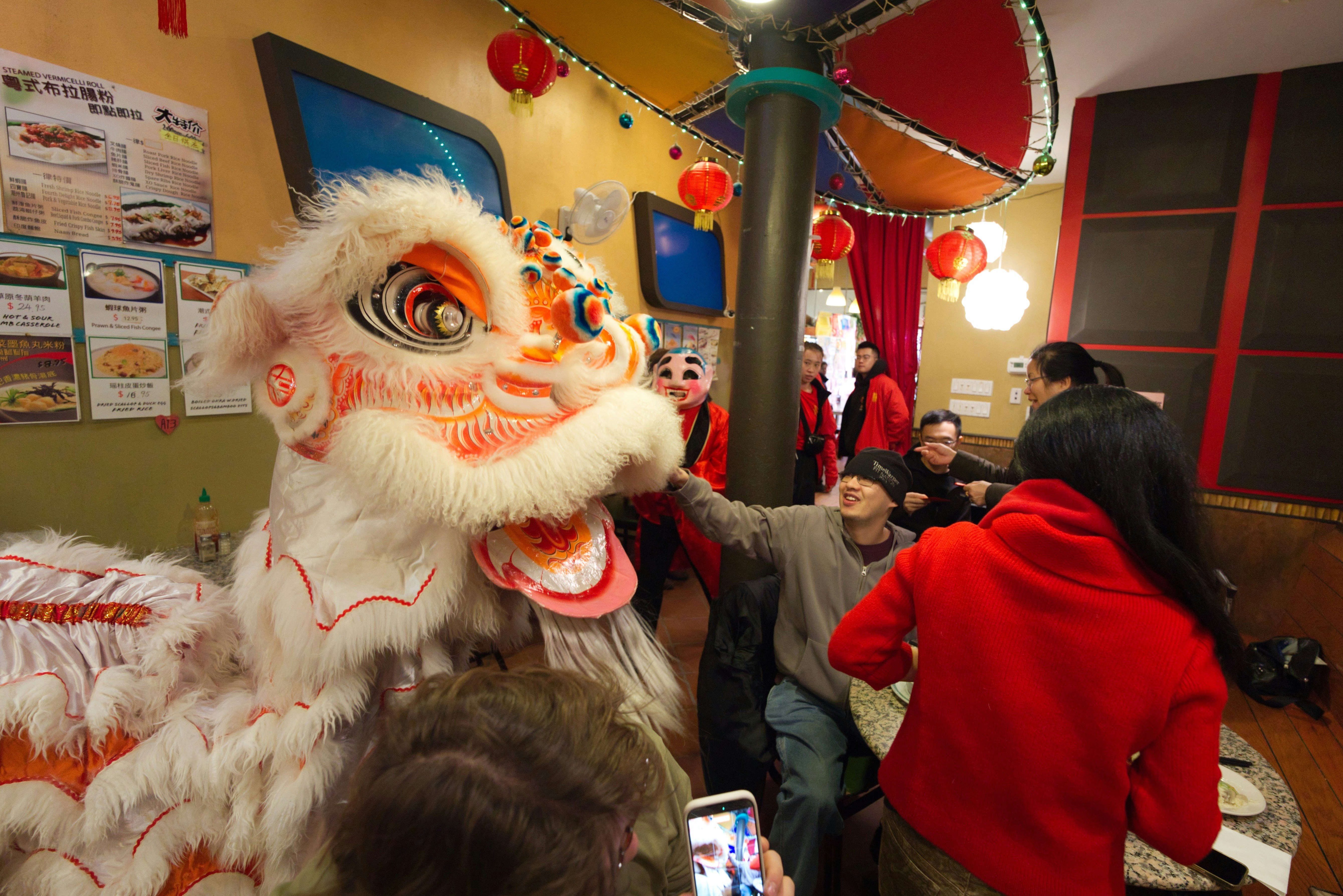 New York, New York - February 28, 2026: Traditional lion dance troupes and thousands of spectators gather on Hester Street for the "Super Saturday" Chinatown Lion Dance Festival and ceremonial firecracker display. Celebrating the 2026 Lunar New Year—the Year of the Fire Horse—the event features rhythmic drumming, vibrant costumes, and the traditional lighting of firecrackers to ward off evil spirits and bring good fortune. The massive street festival in Manhattan's Chinatown is a cornerstone of the city's cultural calendar, showcasing ancestral Chinese traditions, martial arts-infused dance performances, and community celebrations that draw residents and tourists to the historic neighborhood for the final peak of the New Year festivities.