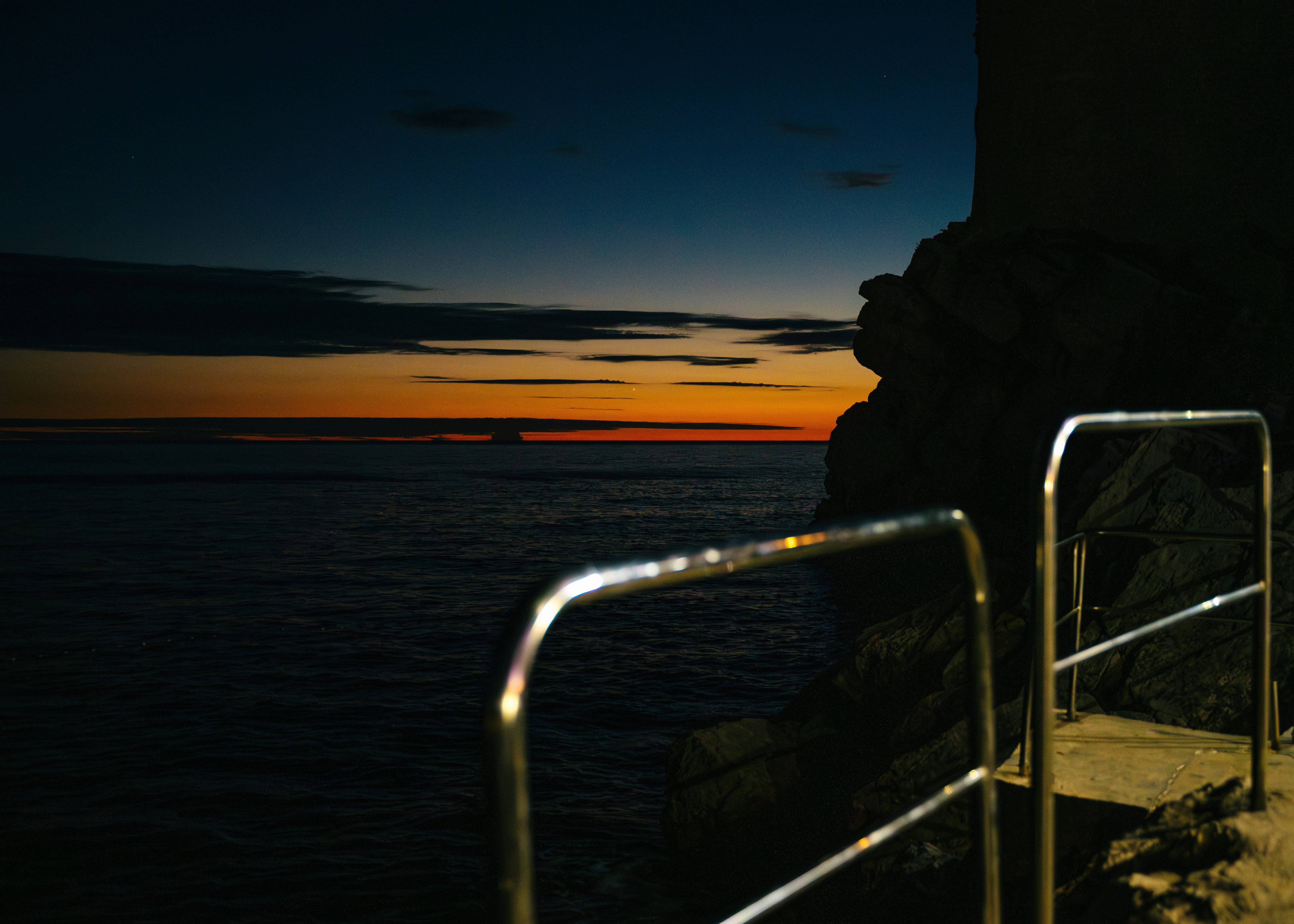 Sunset Over the Railing: A Quiet Cliffside Moment