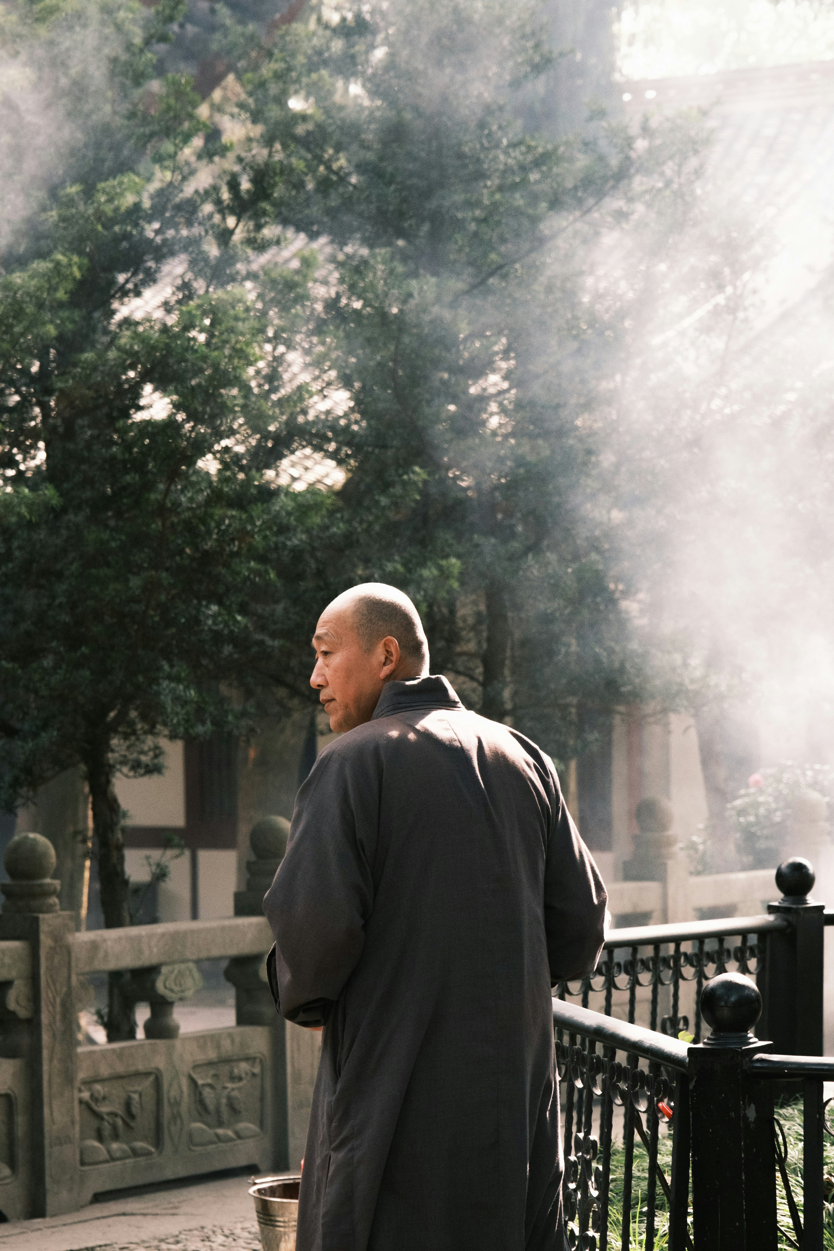 Quiet Resolve: A Monk in Smoke at the Carved Courtyard