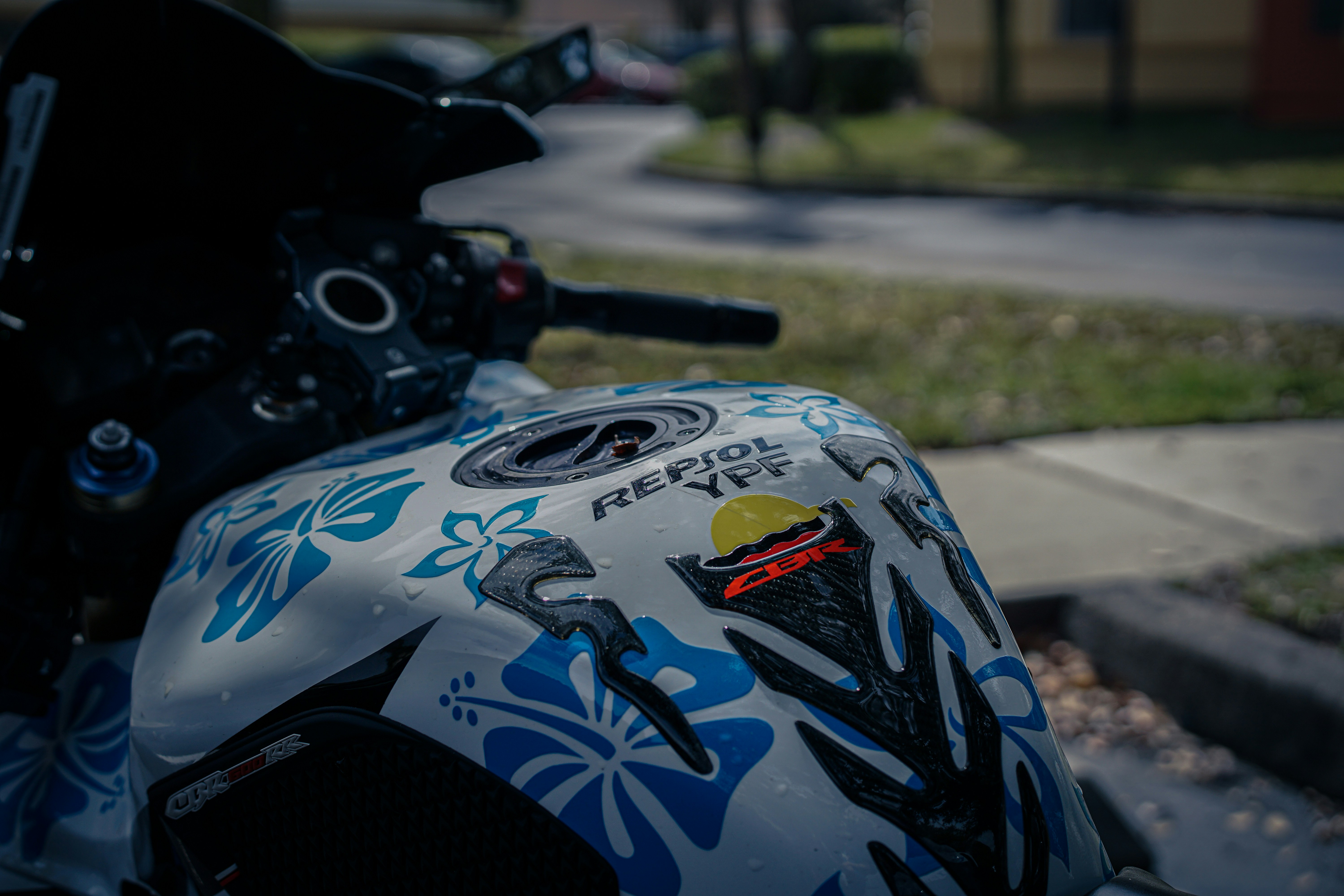 Hawaiian-blue motorcycle licks the curbside light