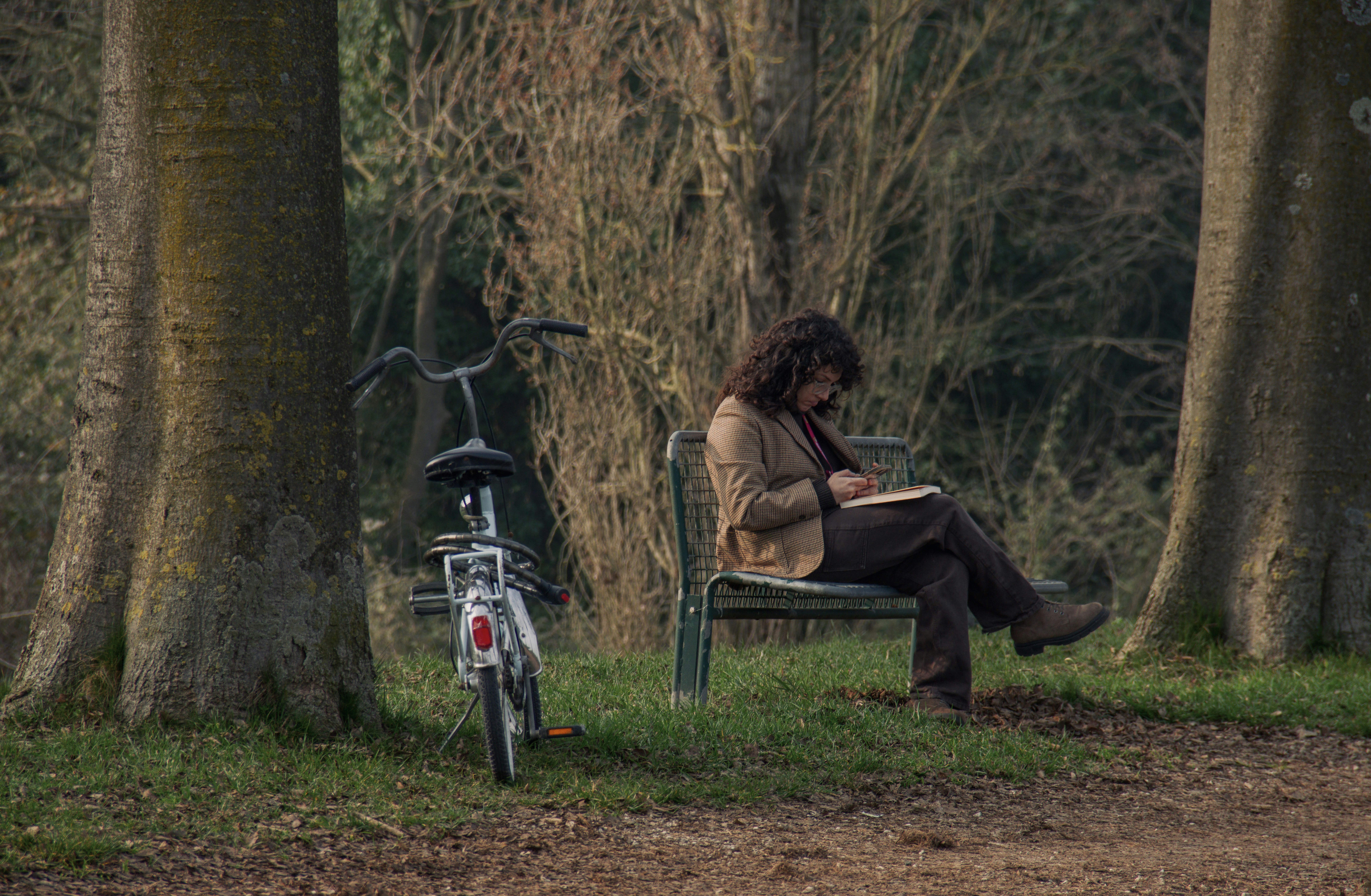 A Quiet Afternoon: Reading by the Park with a Bicycle in the Frame