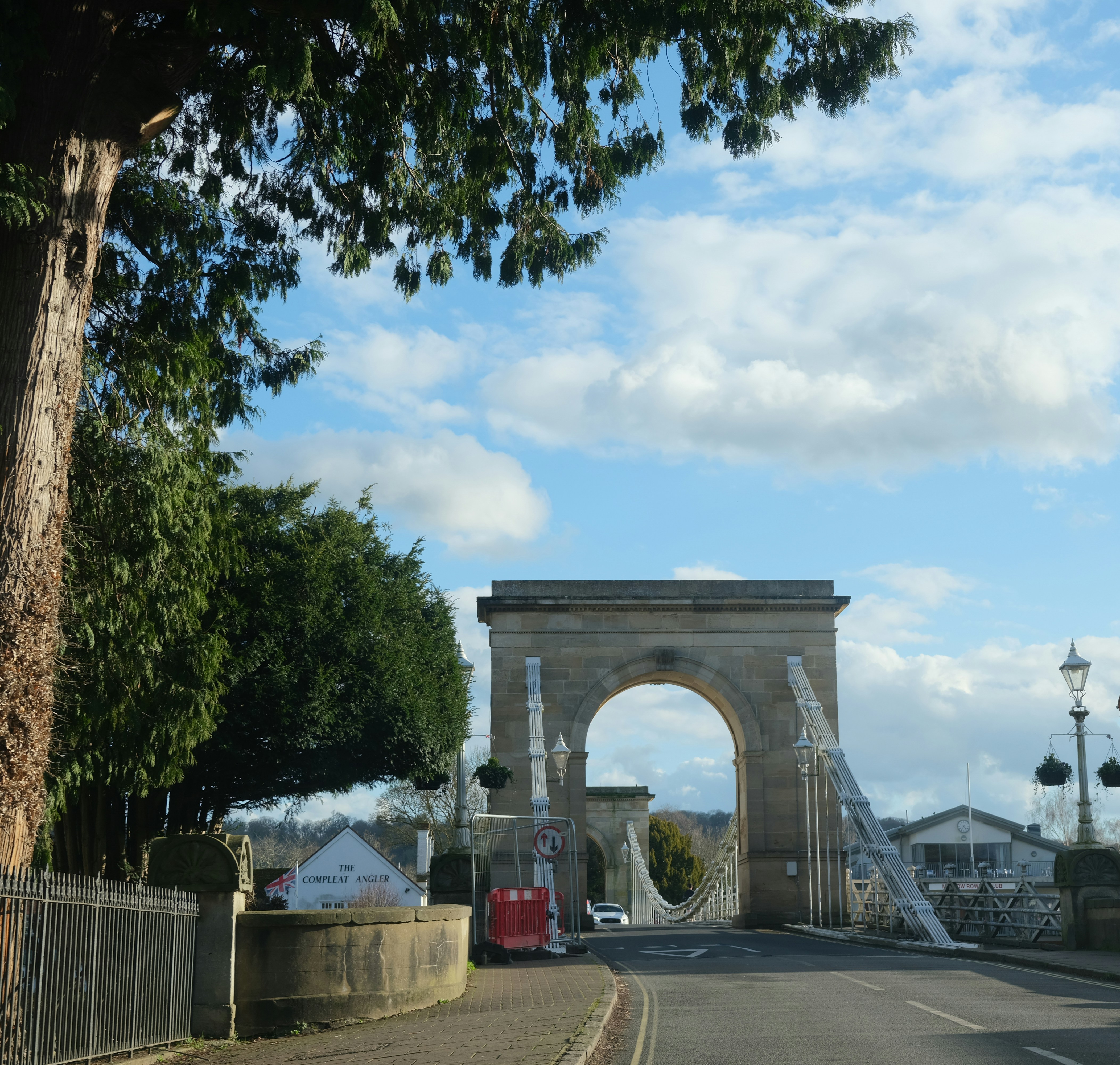 Bridge Archway under a Bright Sky: A Calm Riverfront Approach