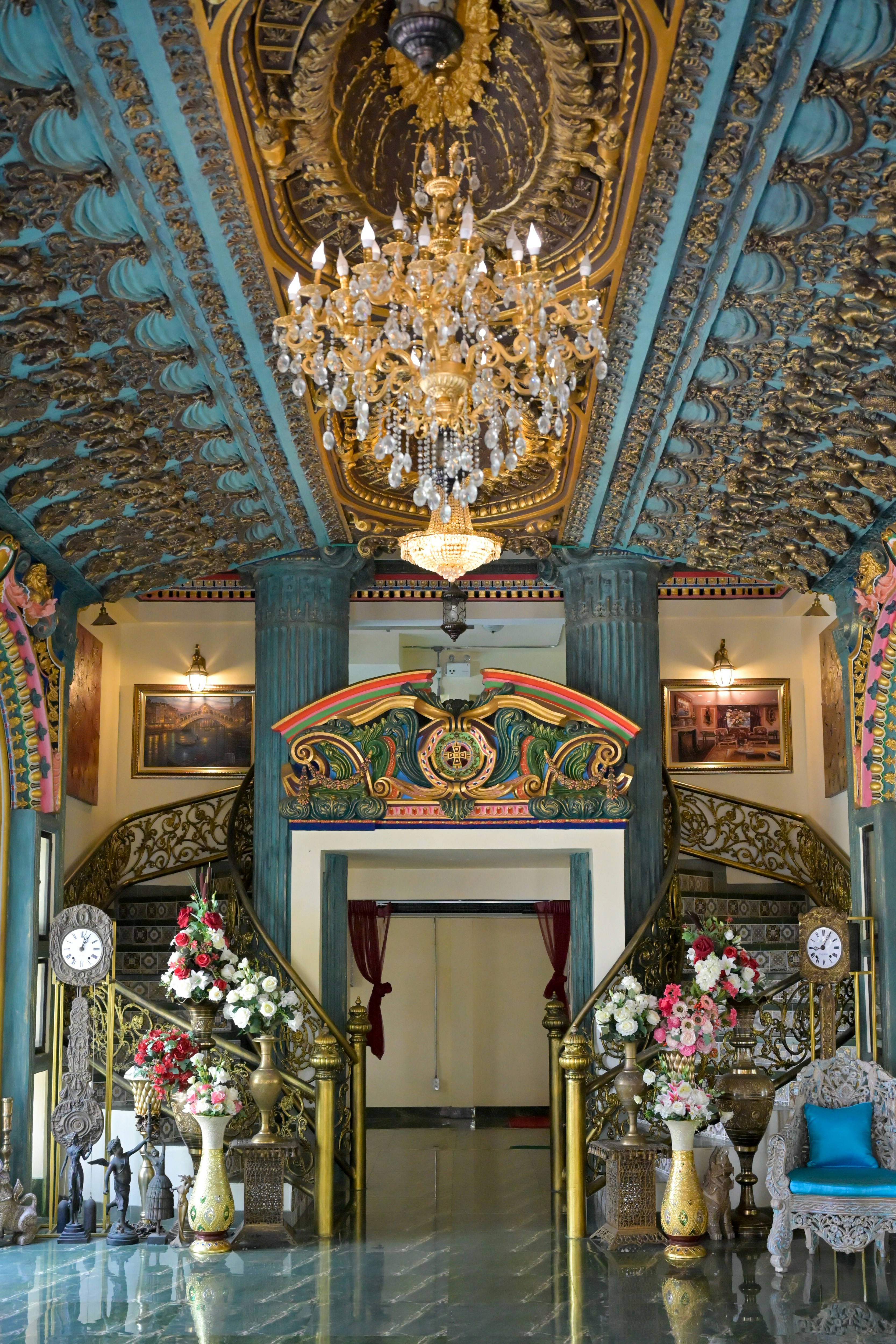 Opulent Entry Hall with Golden Chandelier and Ornate Ceiling