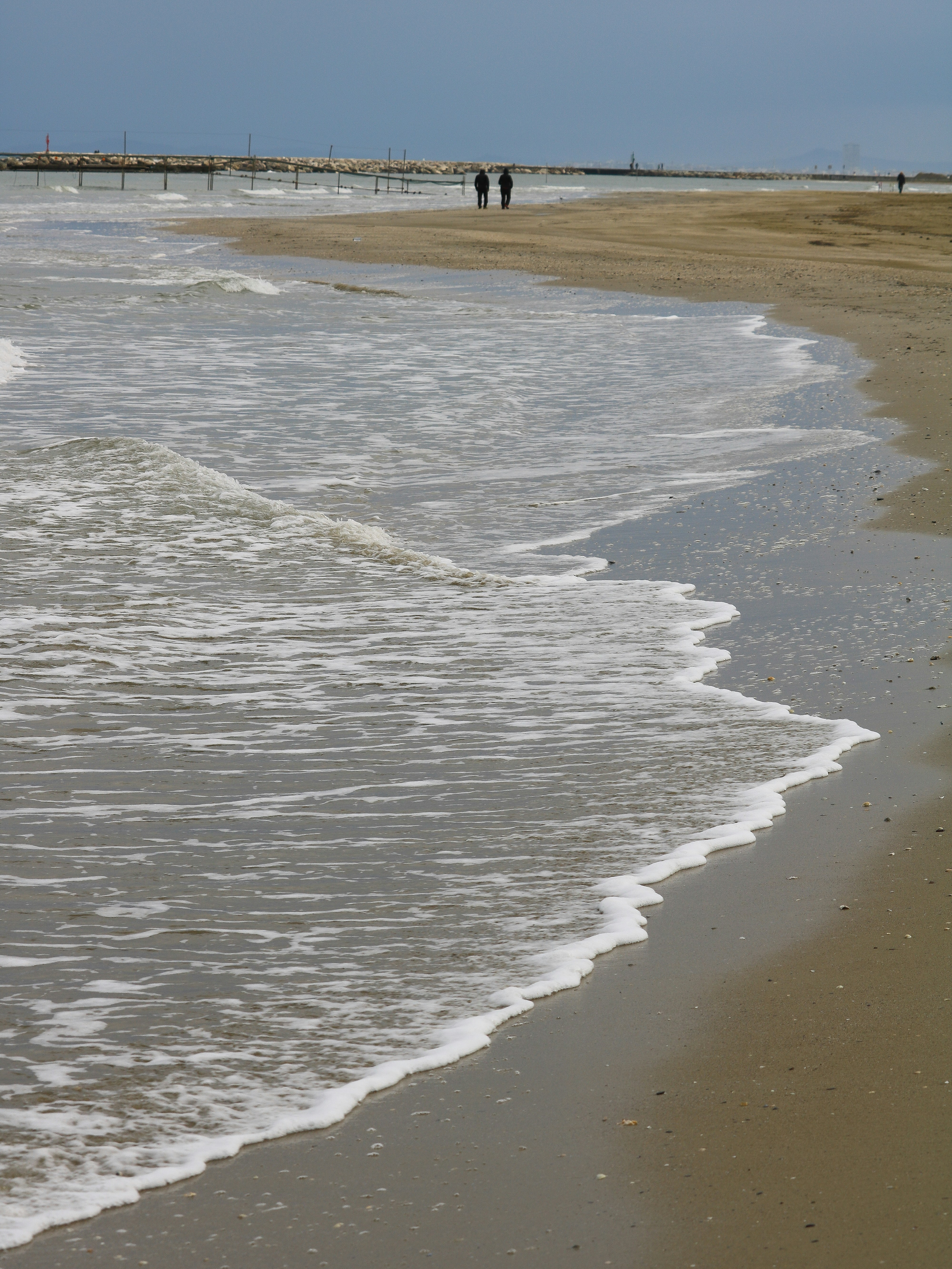 Footprints and Foam on a Quiet Seaside Walk