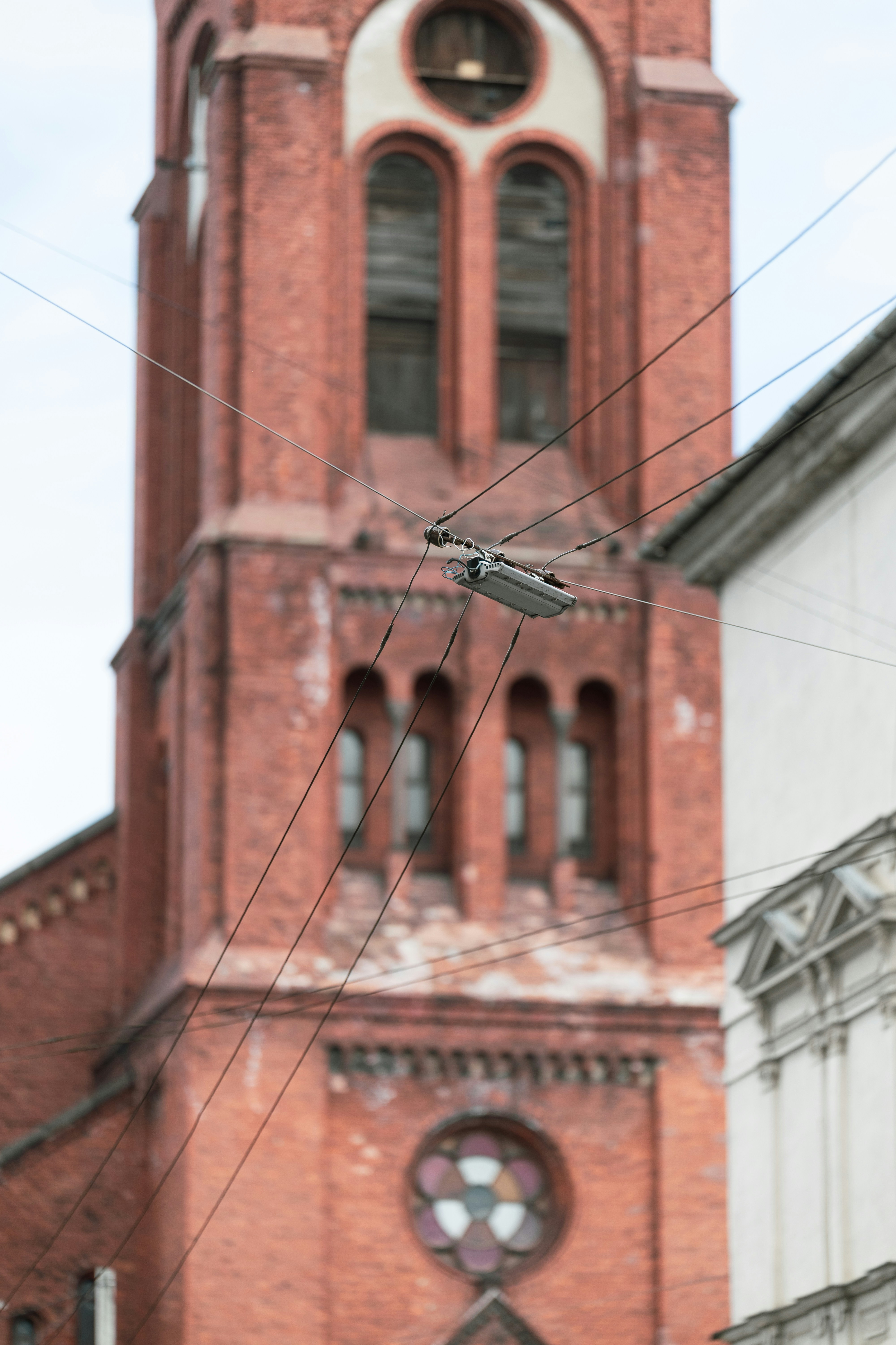 Suspended Lines: A Brick Clocktower Framed by a Suspended Tram Cable Crosshair