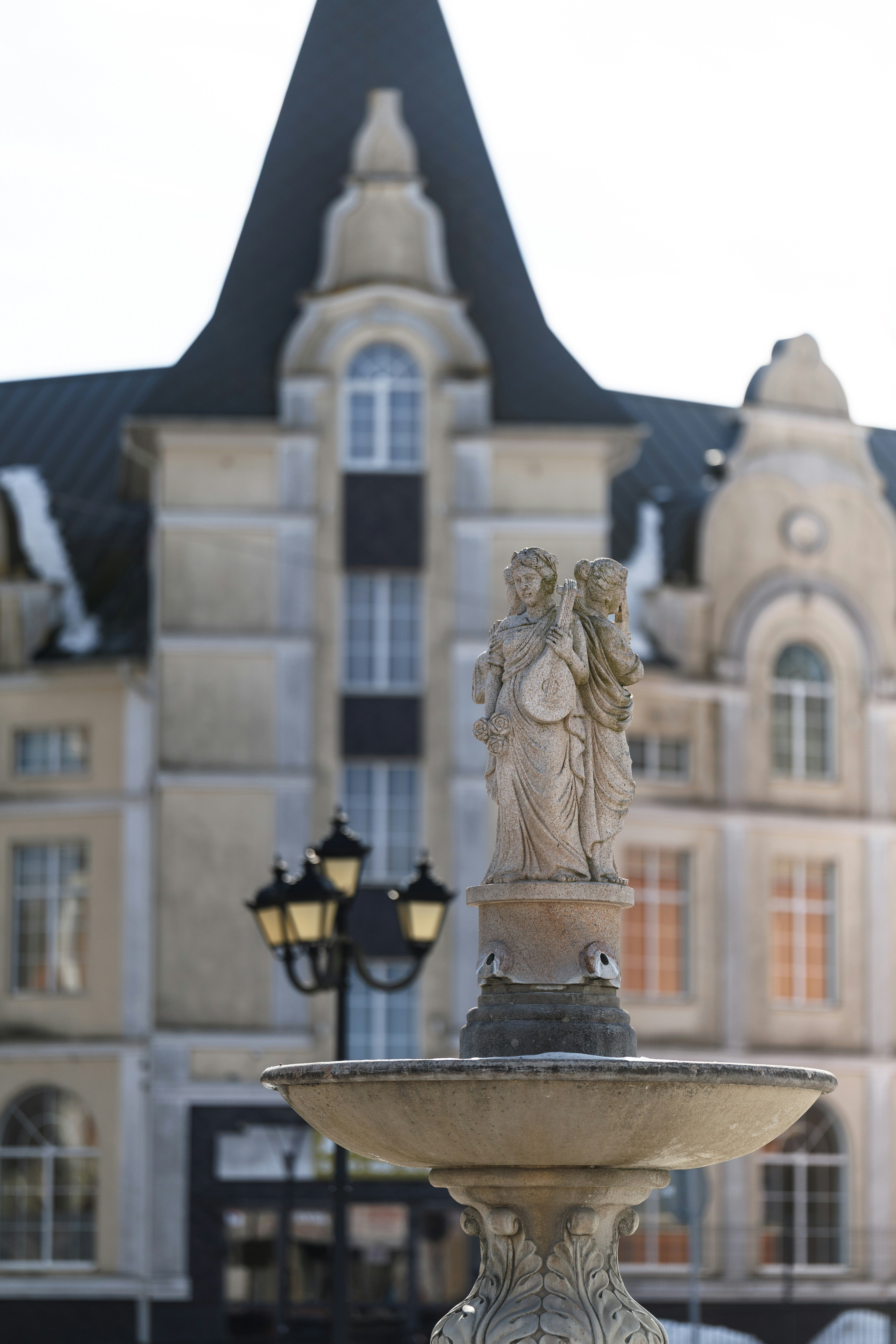 Stone Statue Crowned by a Courtyard Fountain