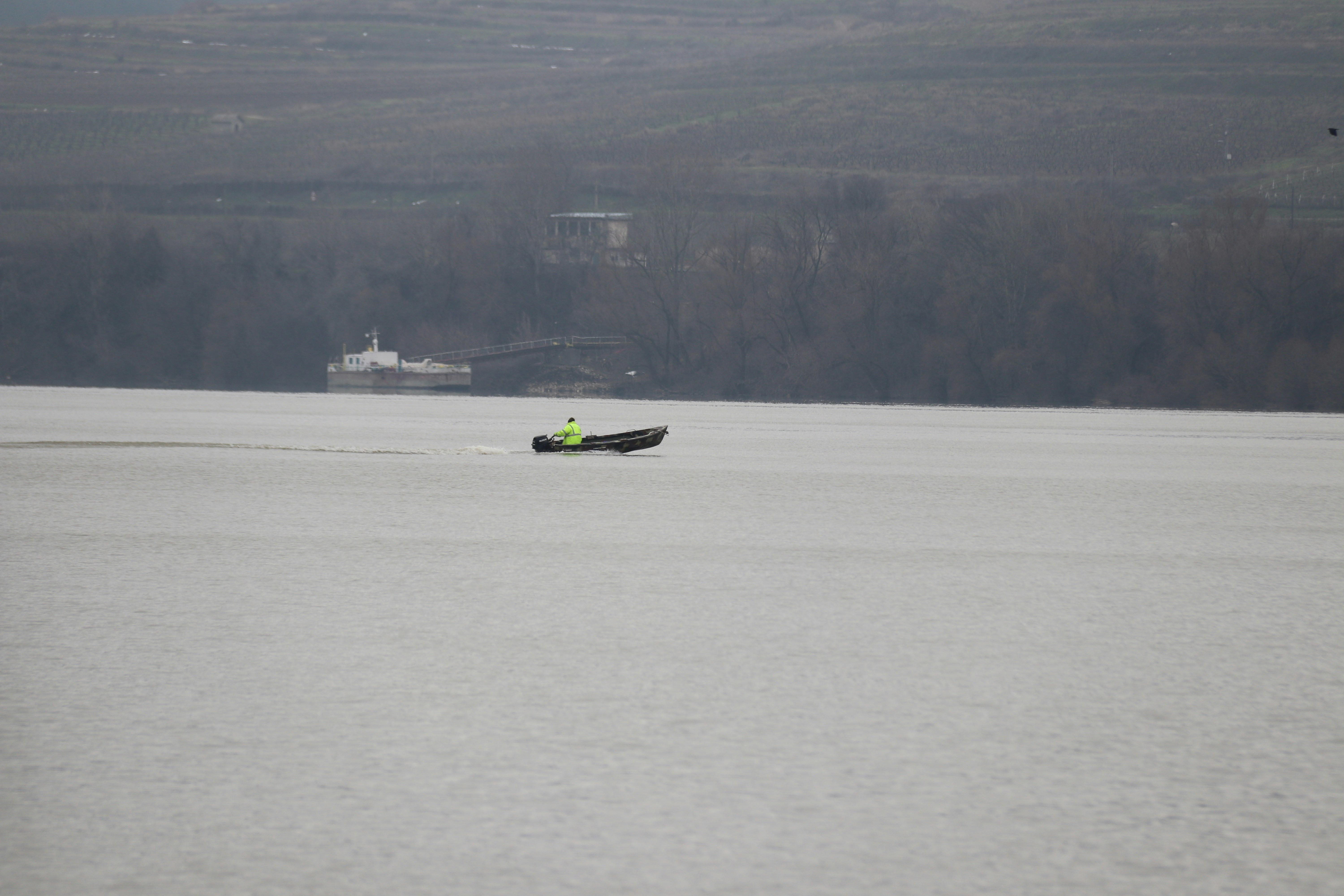 A Lone Boat Slices Across a Quiet Lake at Dusk