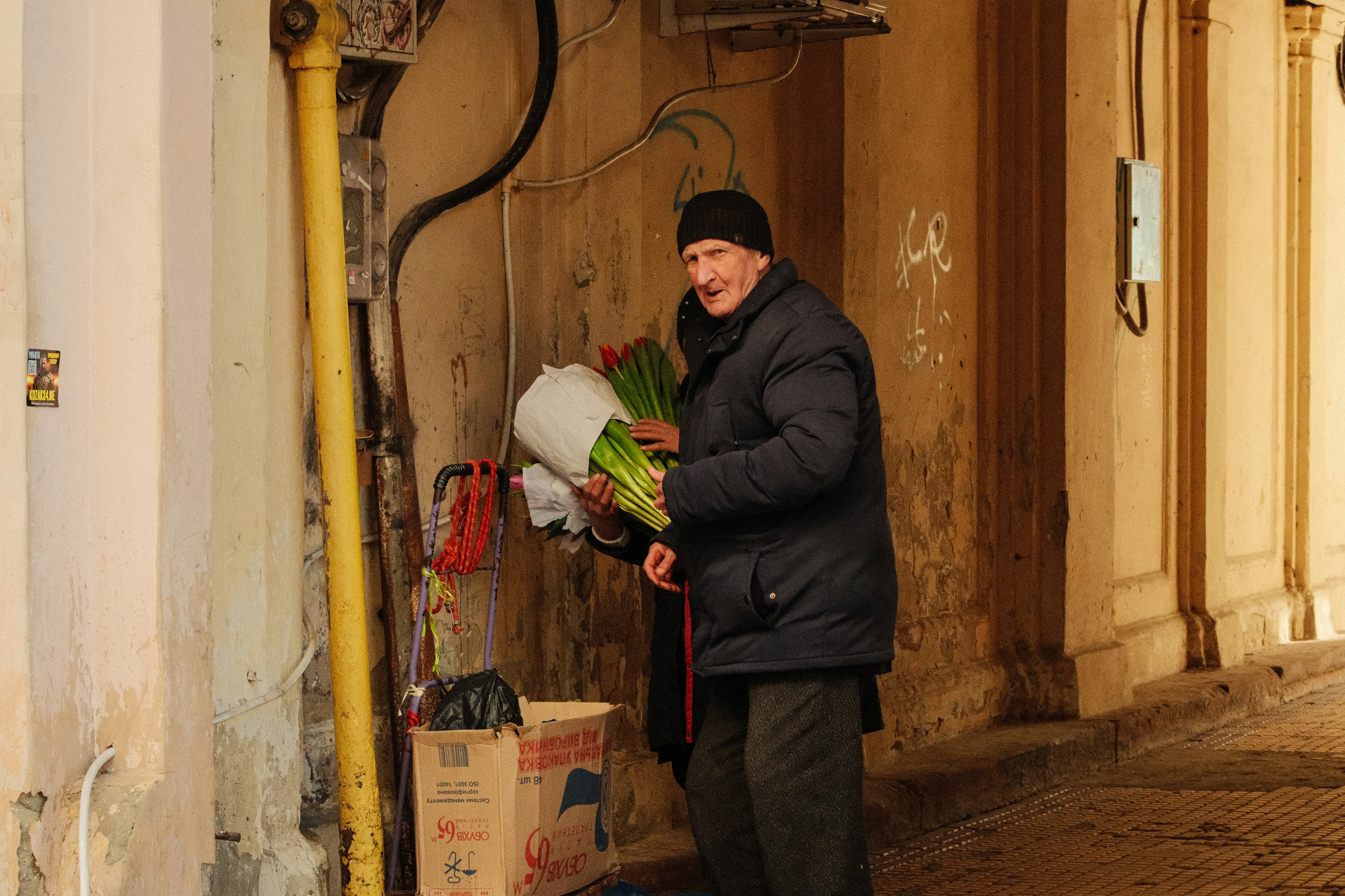 Street Vendor with Bouquet Near a Weathered Archway