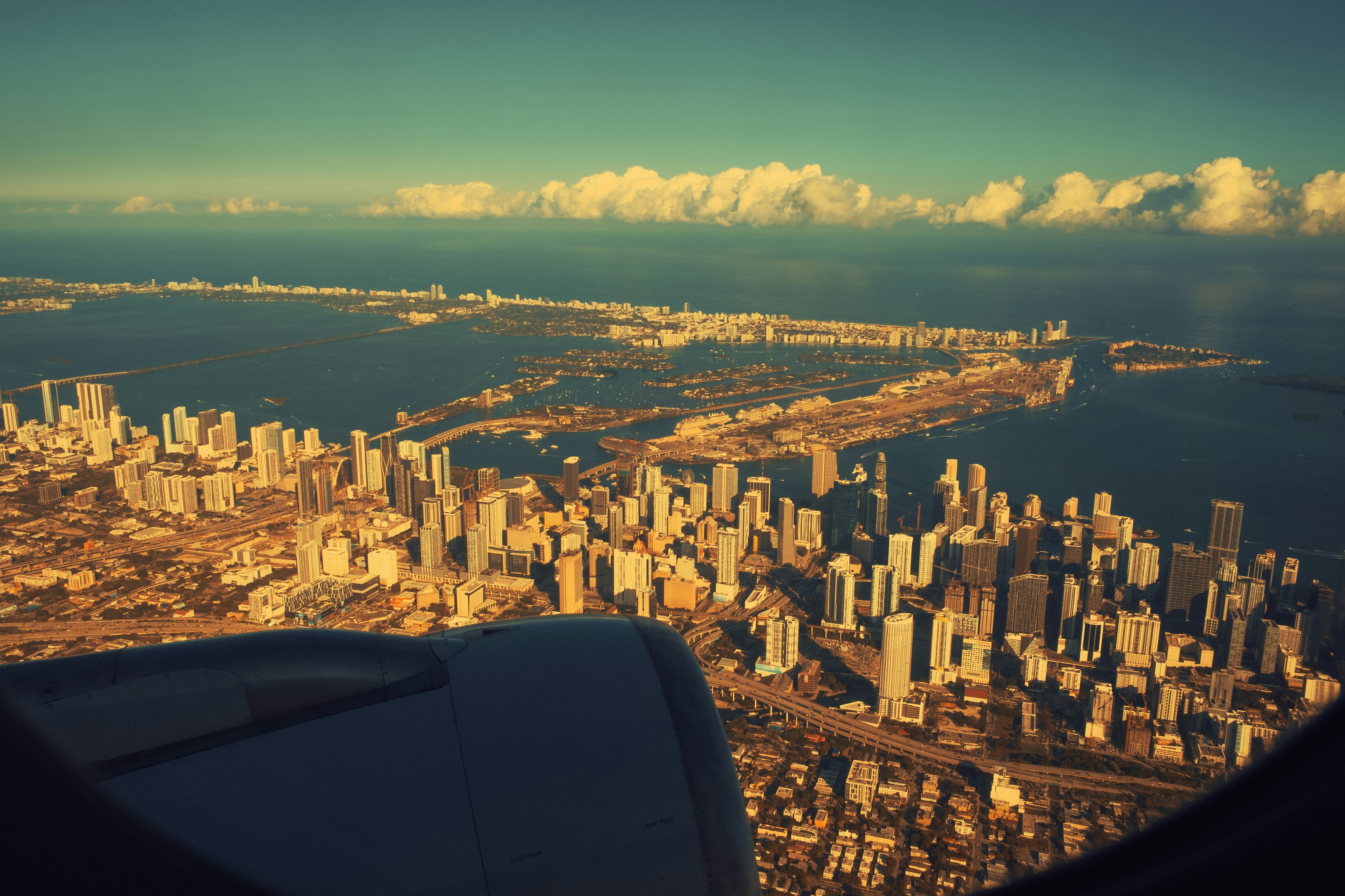 Cityscape Asymmetry: Wingtip View Over a Sunlit Harbor