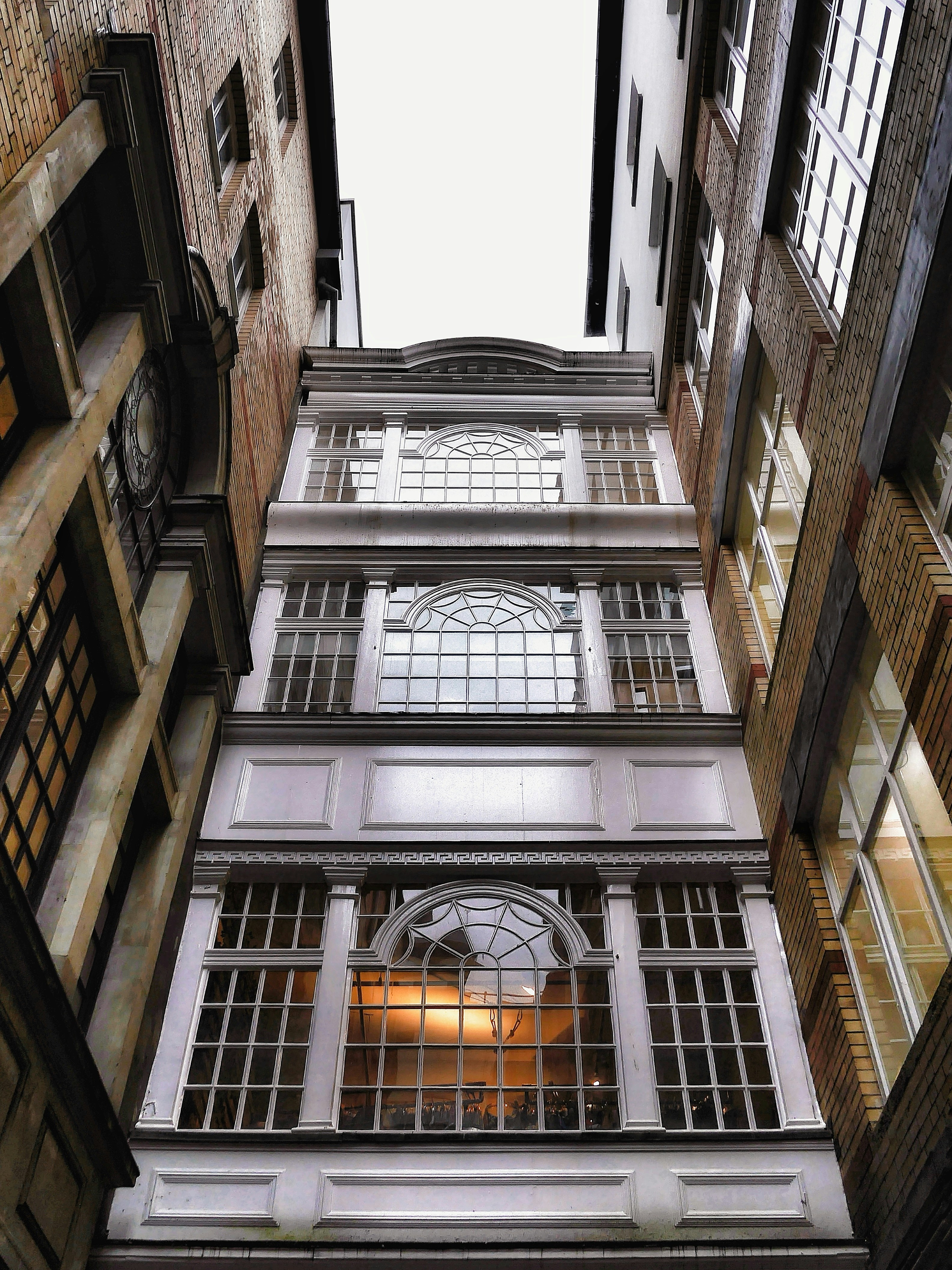 Arched Facade Rising Between Brick Wings