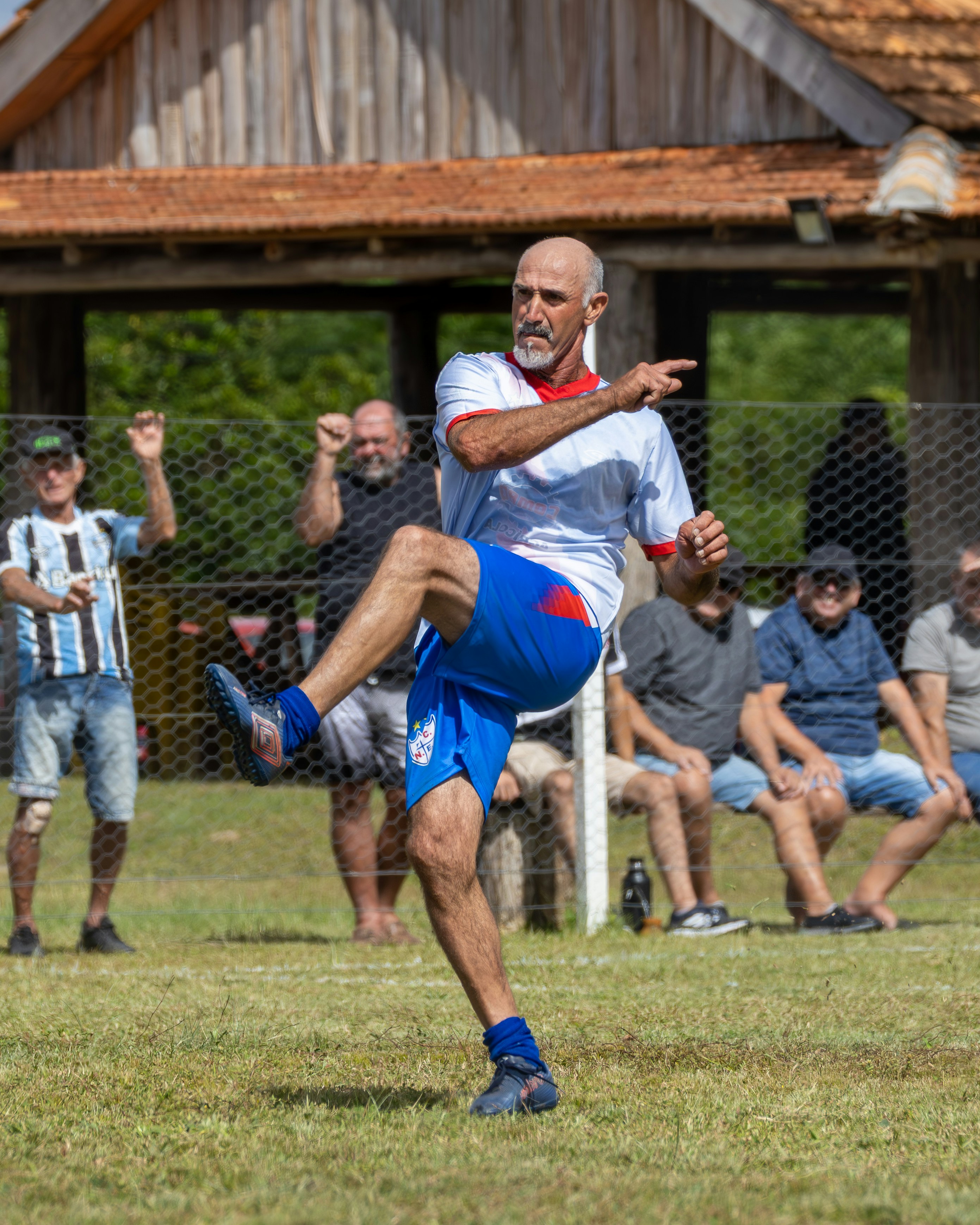 Midair Strike: A Soccer Player Leaps to Defend in a Rural Match