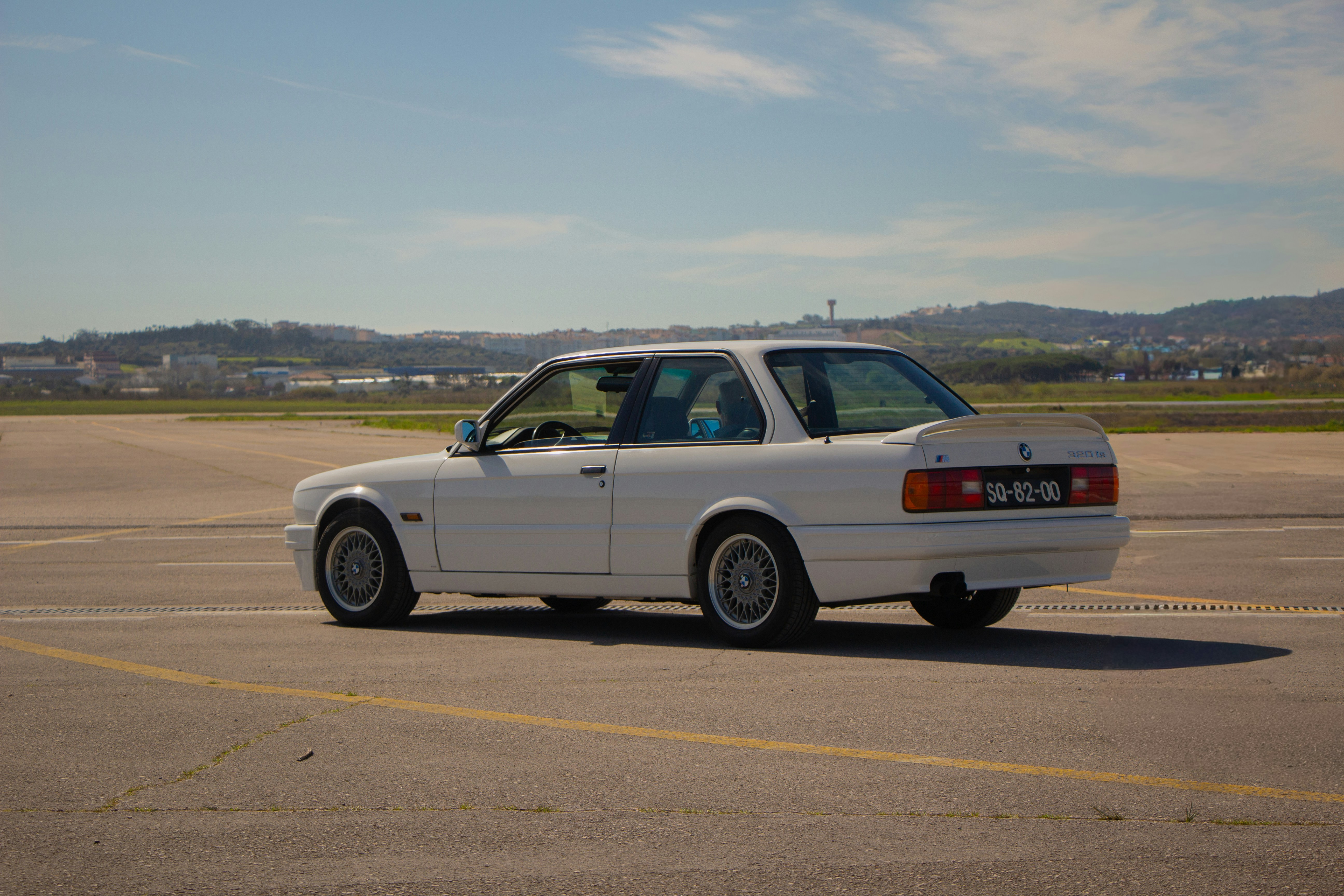 White Station Wagon on an Open Tarmac Under a Clear Sky