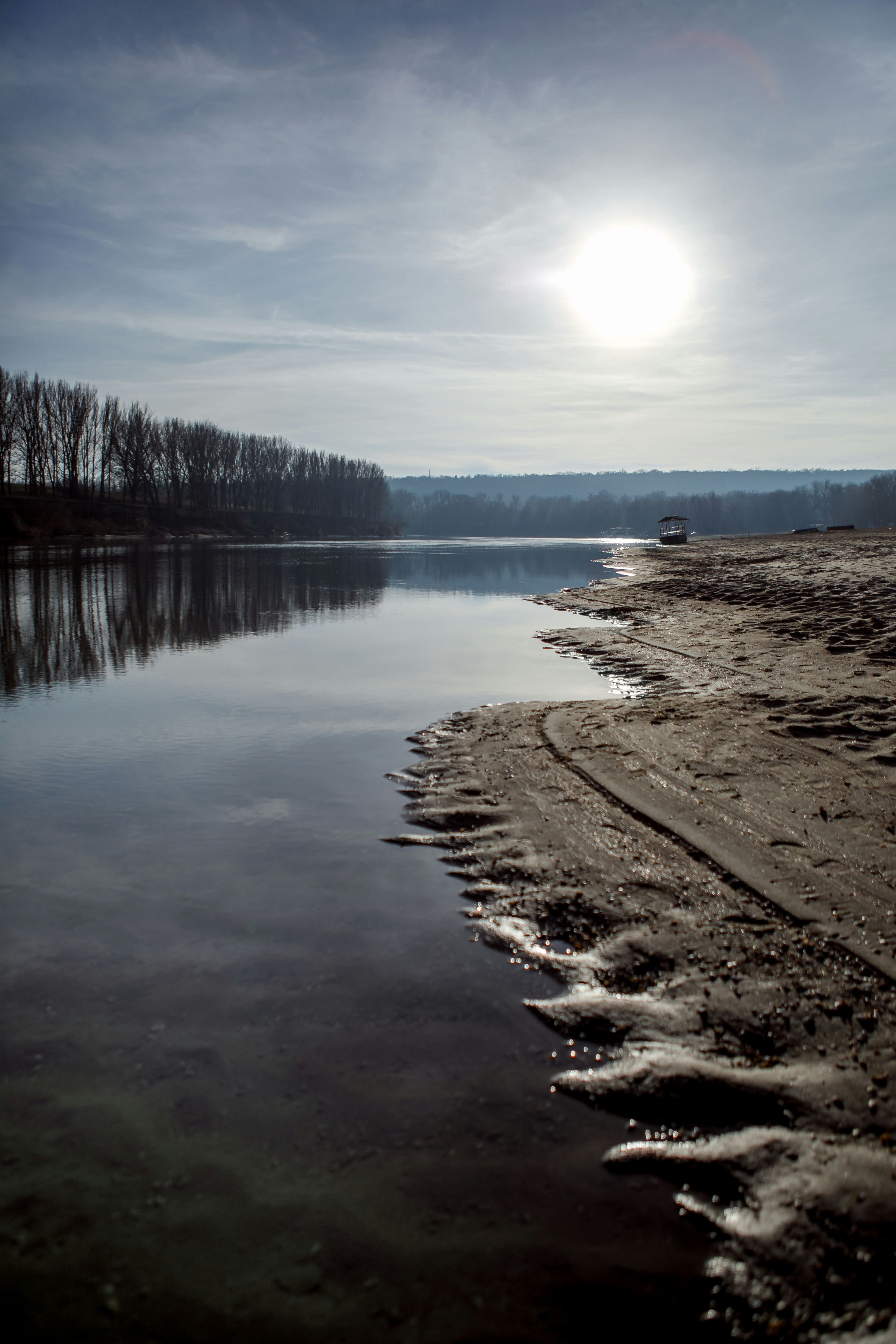 Riverbank Quiet: The Sun Reflects Along a Narrow Shore