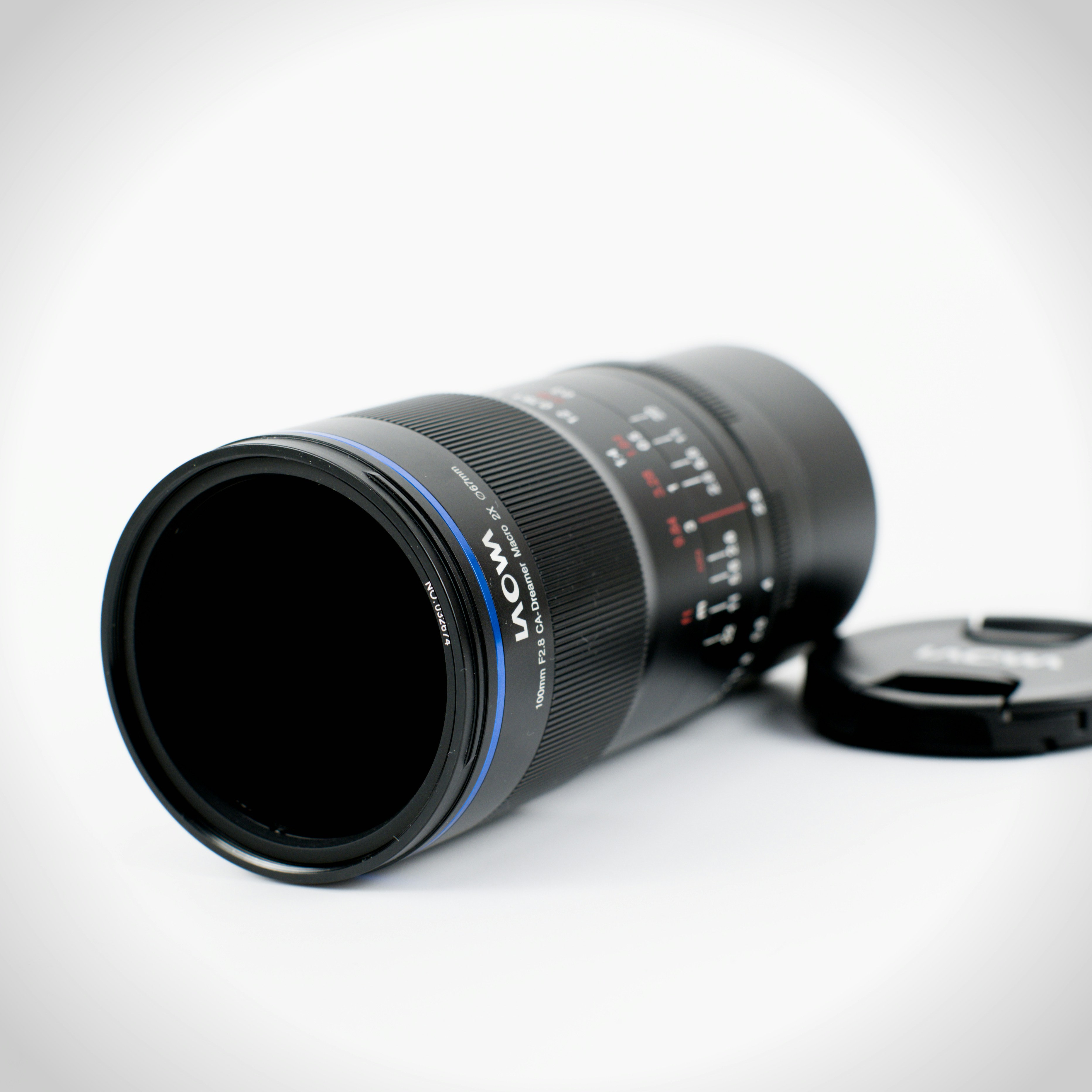 Canon of Focus: A close-up on a professional telephoto lens resting on a white stage