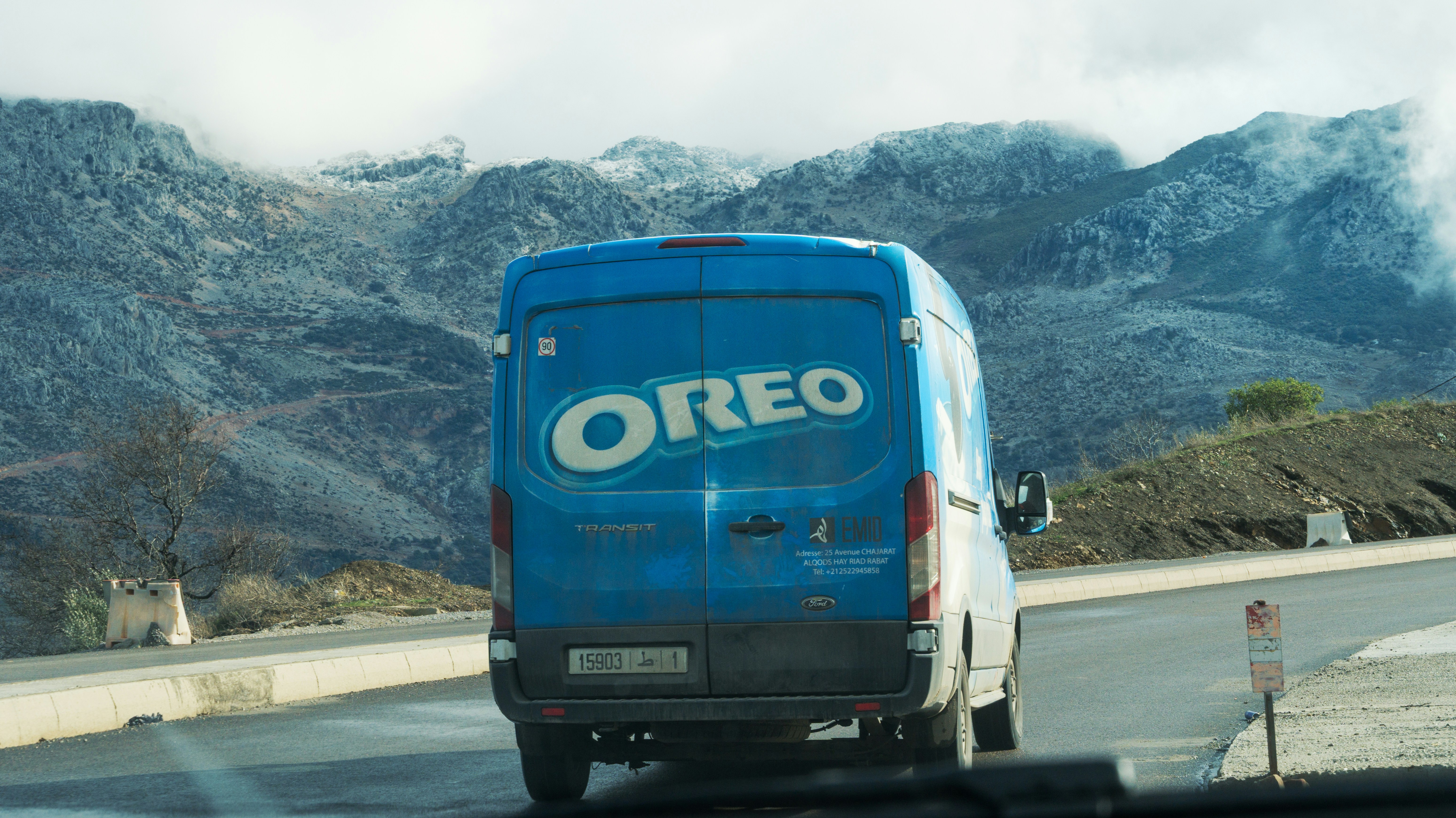 Blue Oreo Van on a Winding Mountain Road