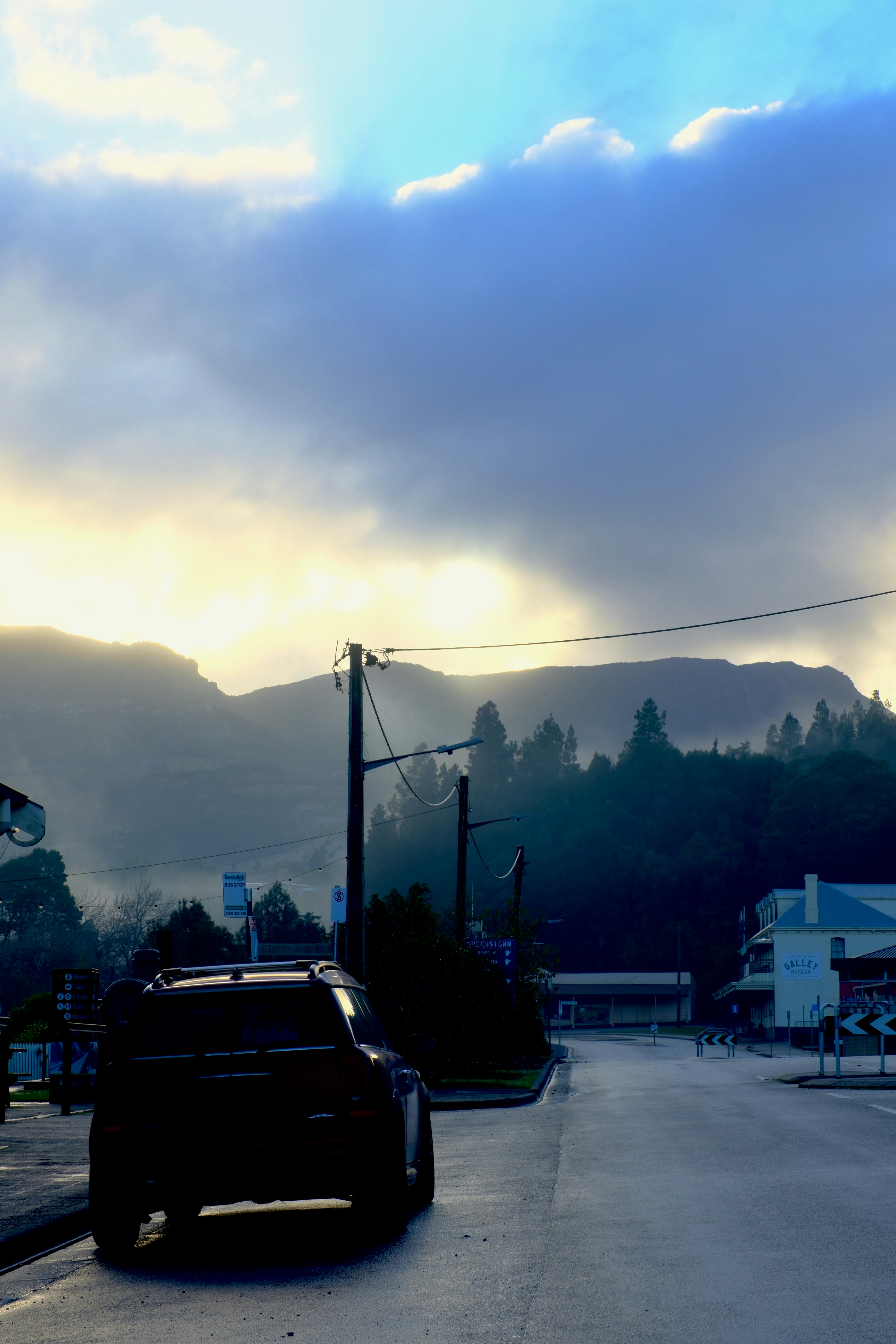 Vehicle at Dawn: Quiet Street Escapes into Blue Mist