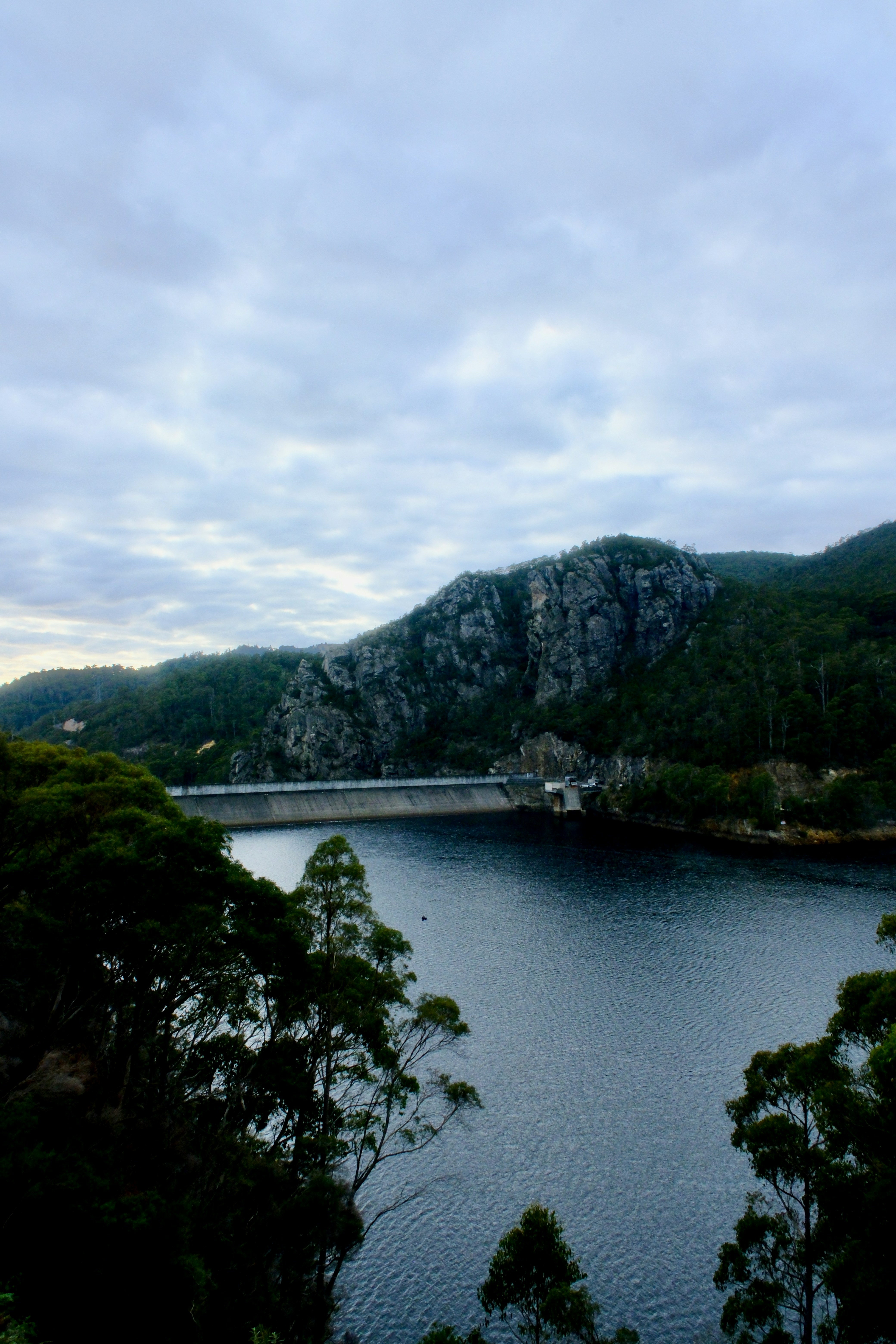 Serene Reservoir Mirror: Cliff, Water, and Pine
