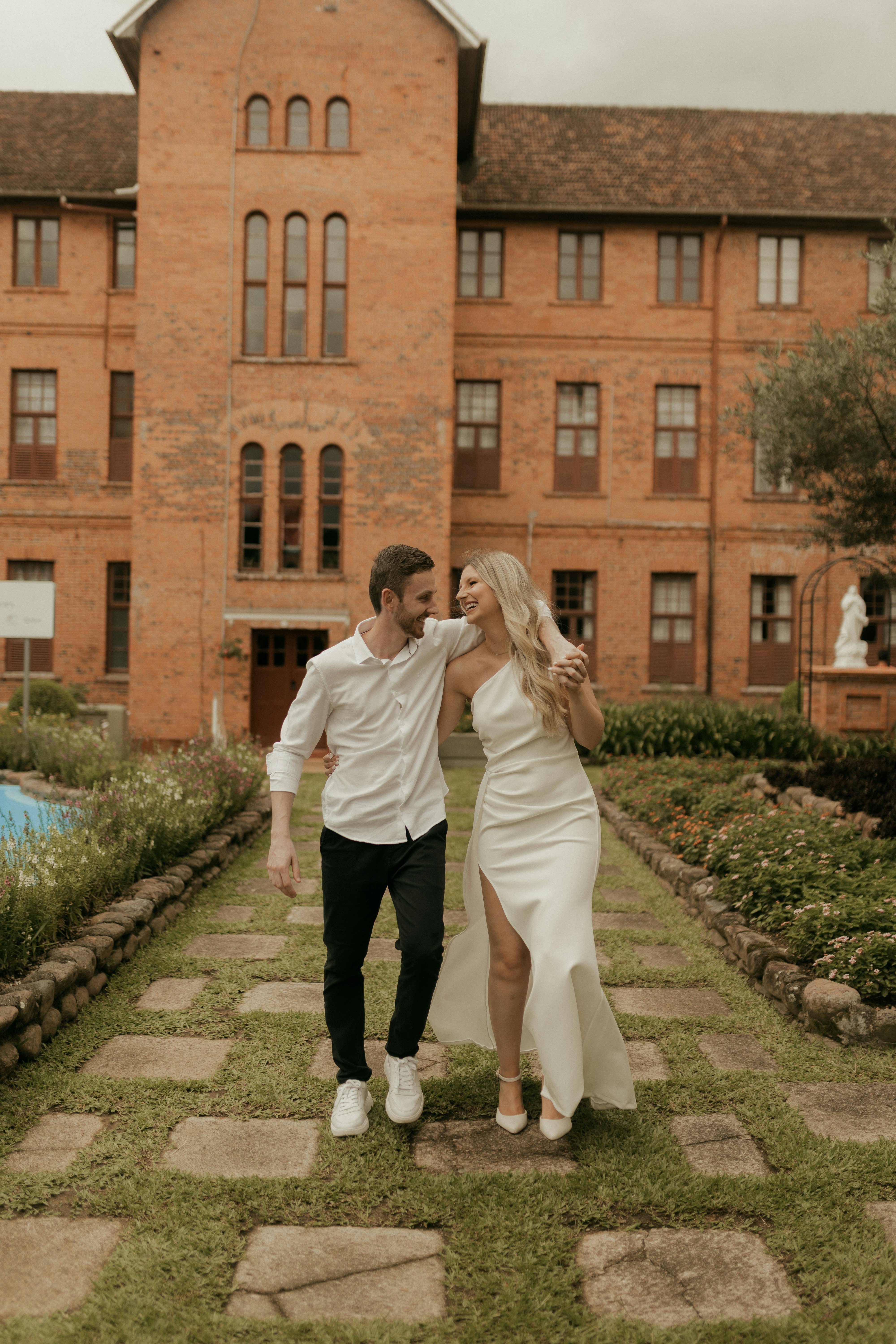 Duo in White: A Moment on Brick Courtyard Path