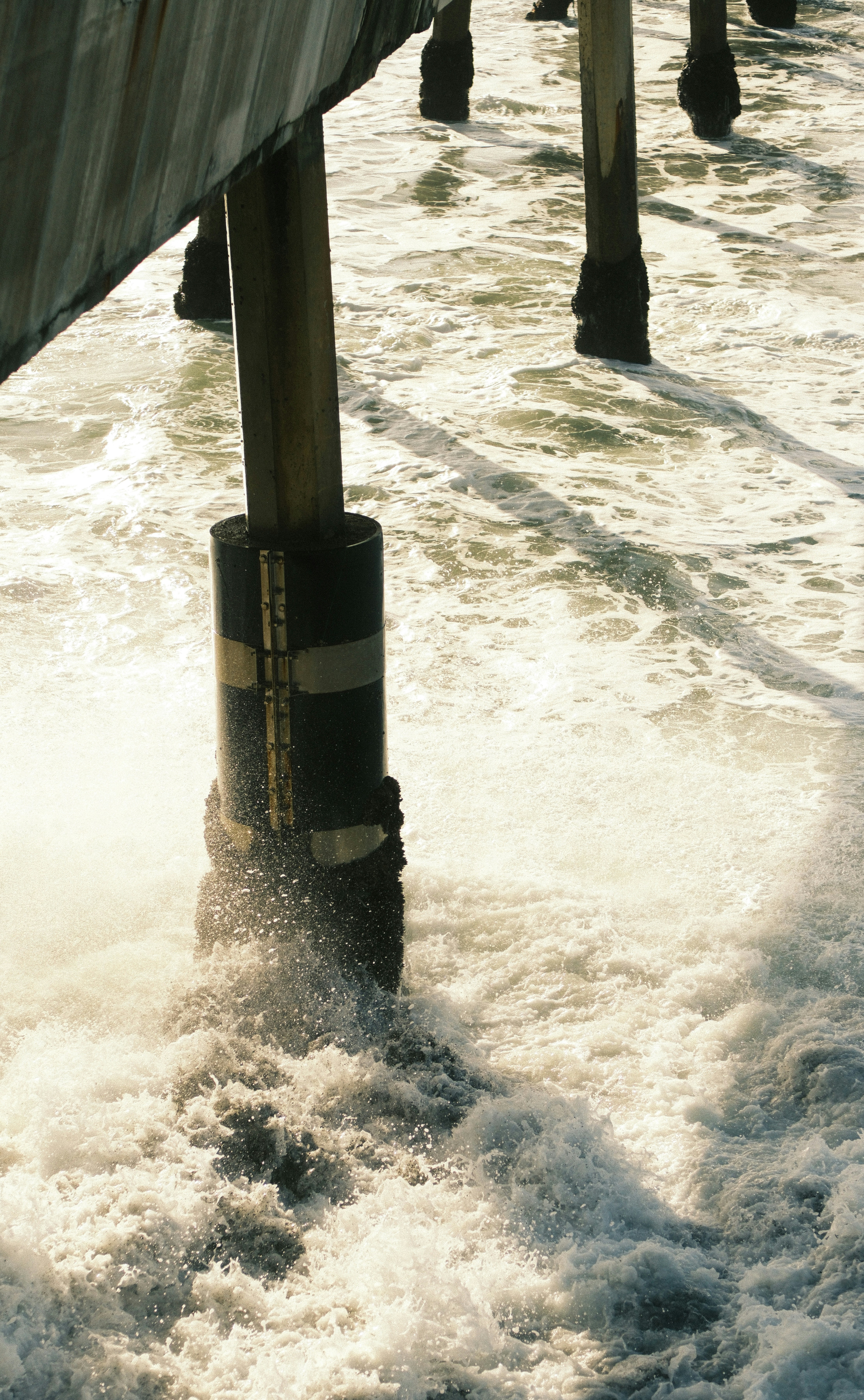 Support Pillars Carving Through Tidal Foam Under the Pier