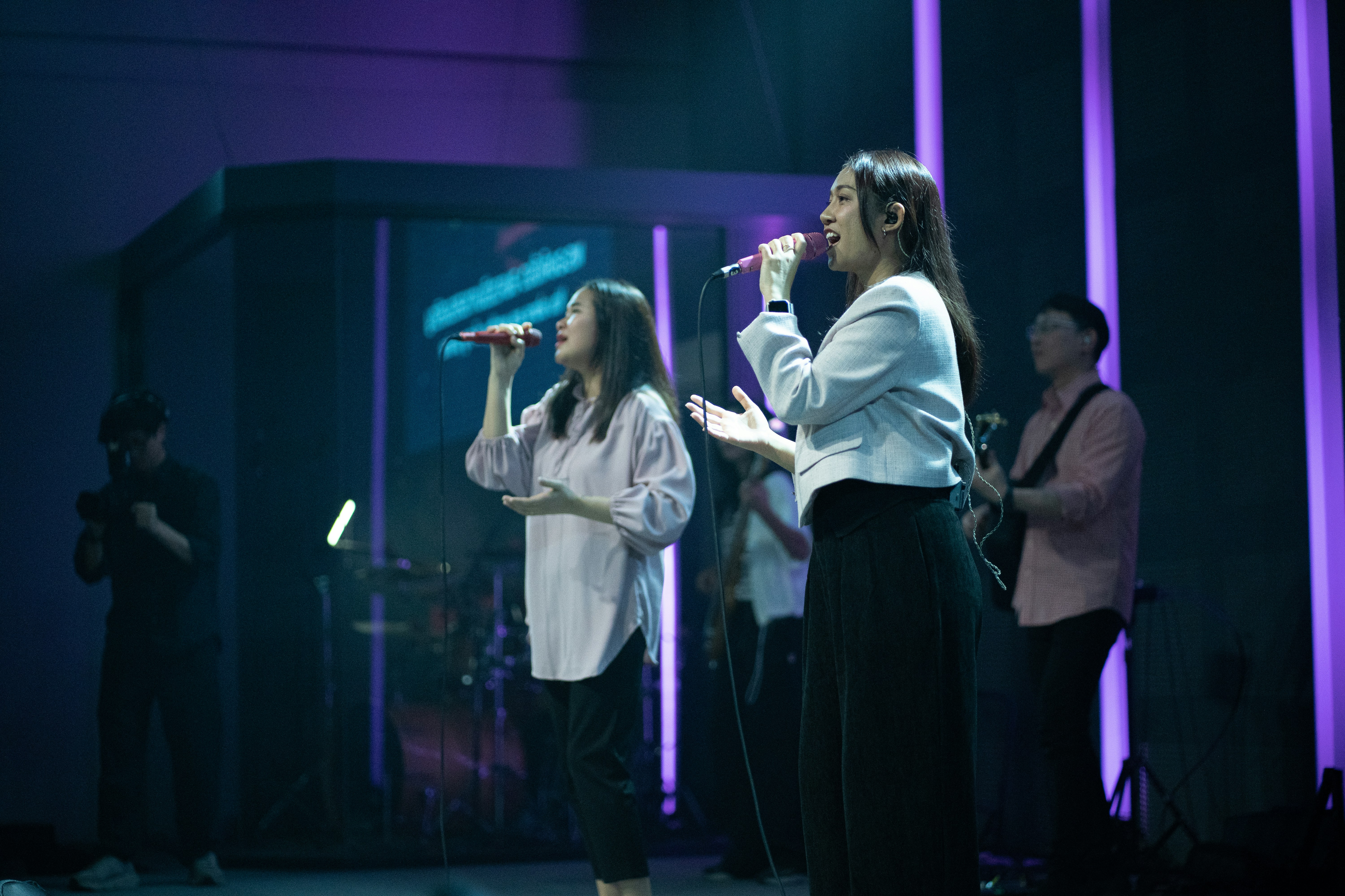 Neon-lit Voices: A Duo of Singers in a Modern Stage