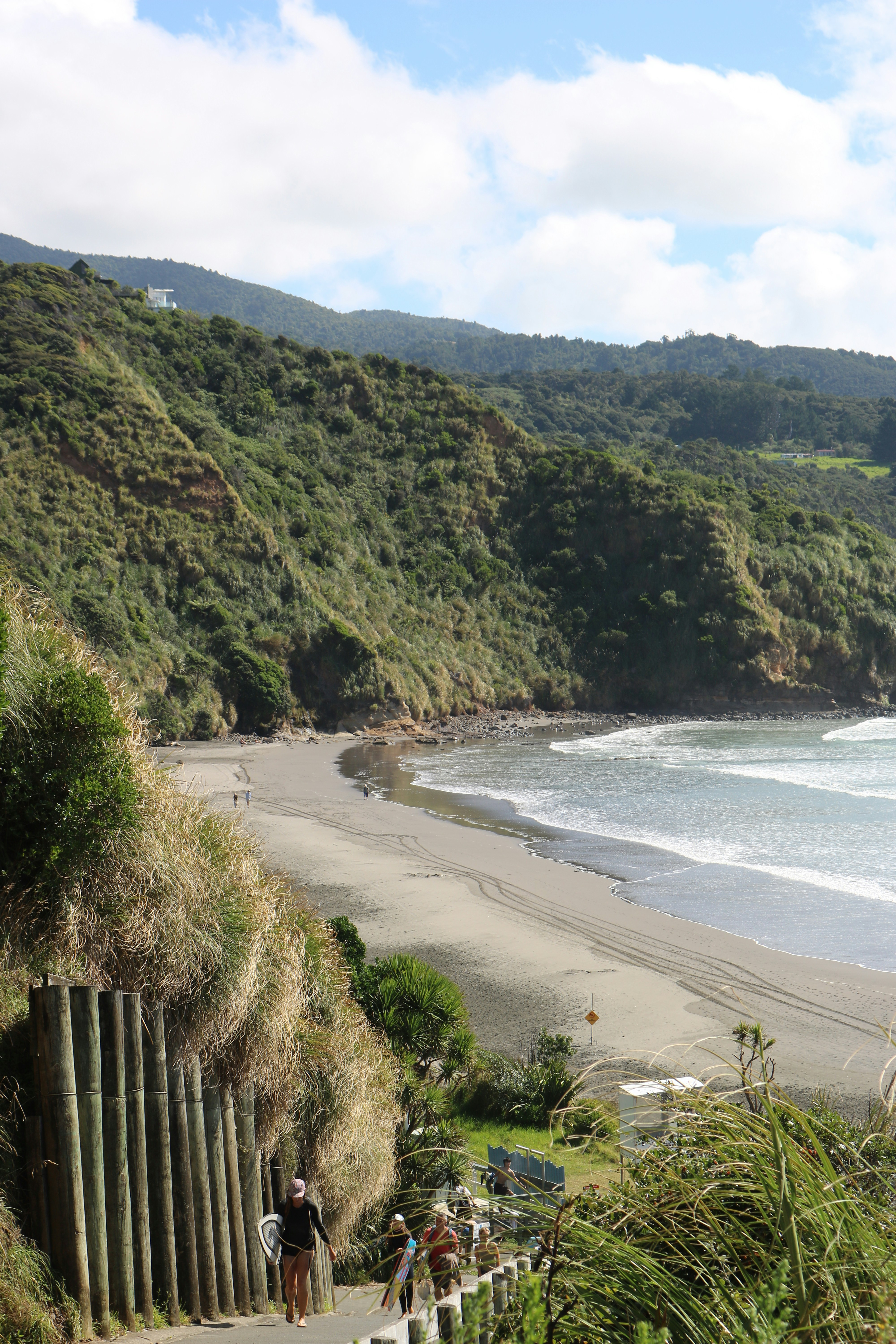 Pathway to the Cove: Sunlit Beach Between Dunes and Cliffside Forest