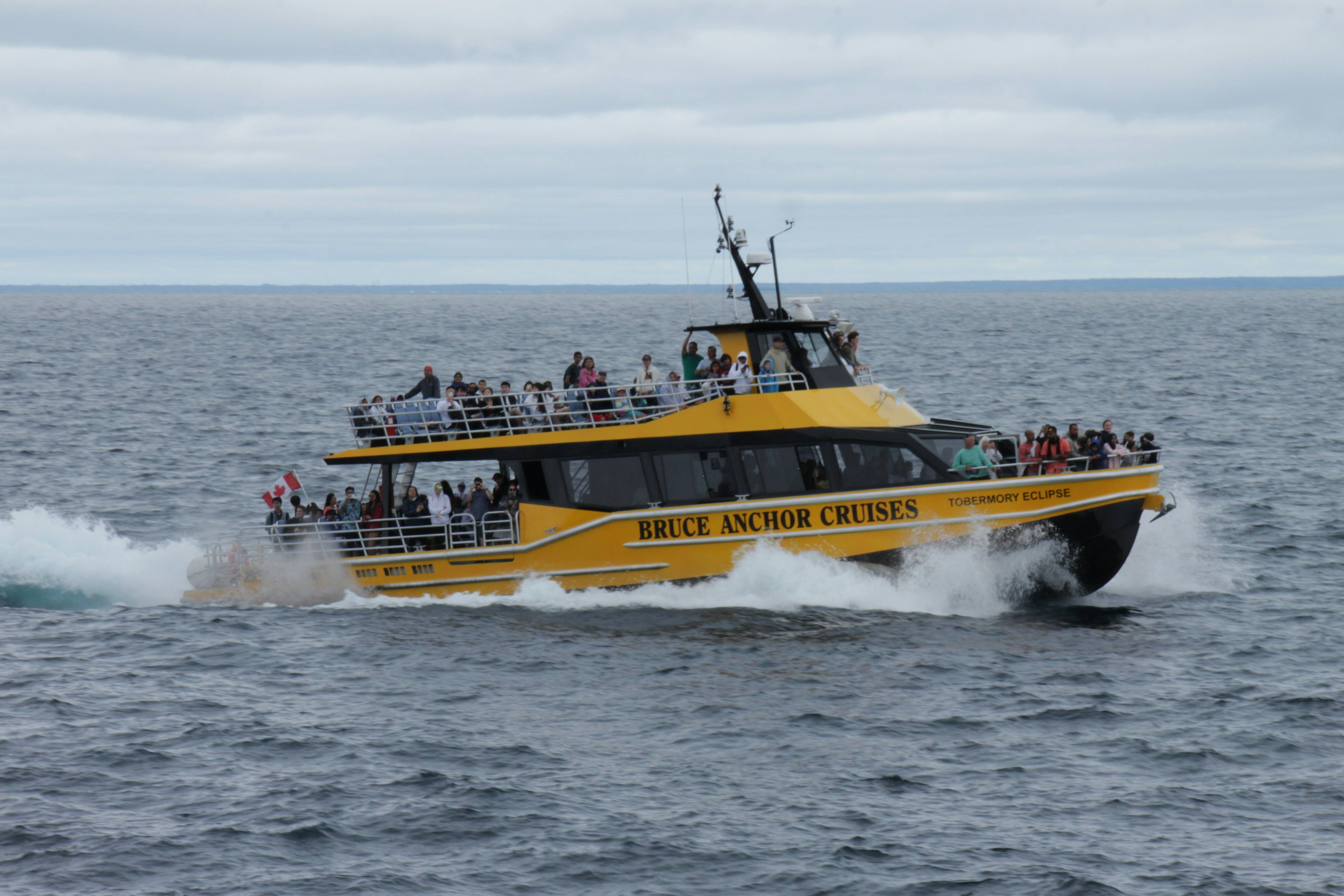 Bright Yellow Cruise Ship Races Across Dark Blue Waters