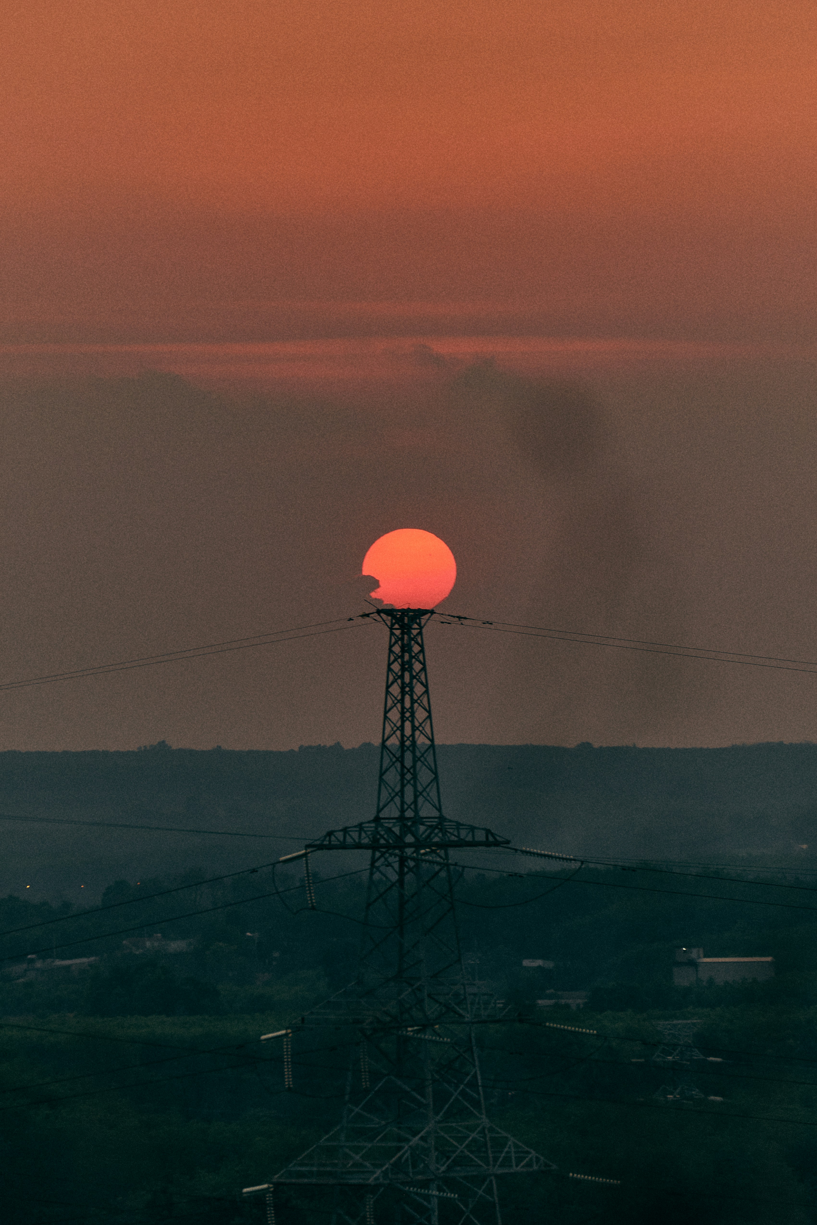 Red Sun on a Transmission Tower: Dusk over Steel and Horizon