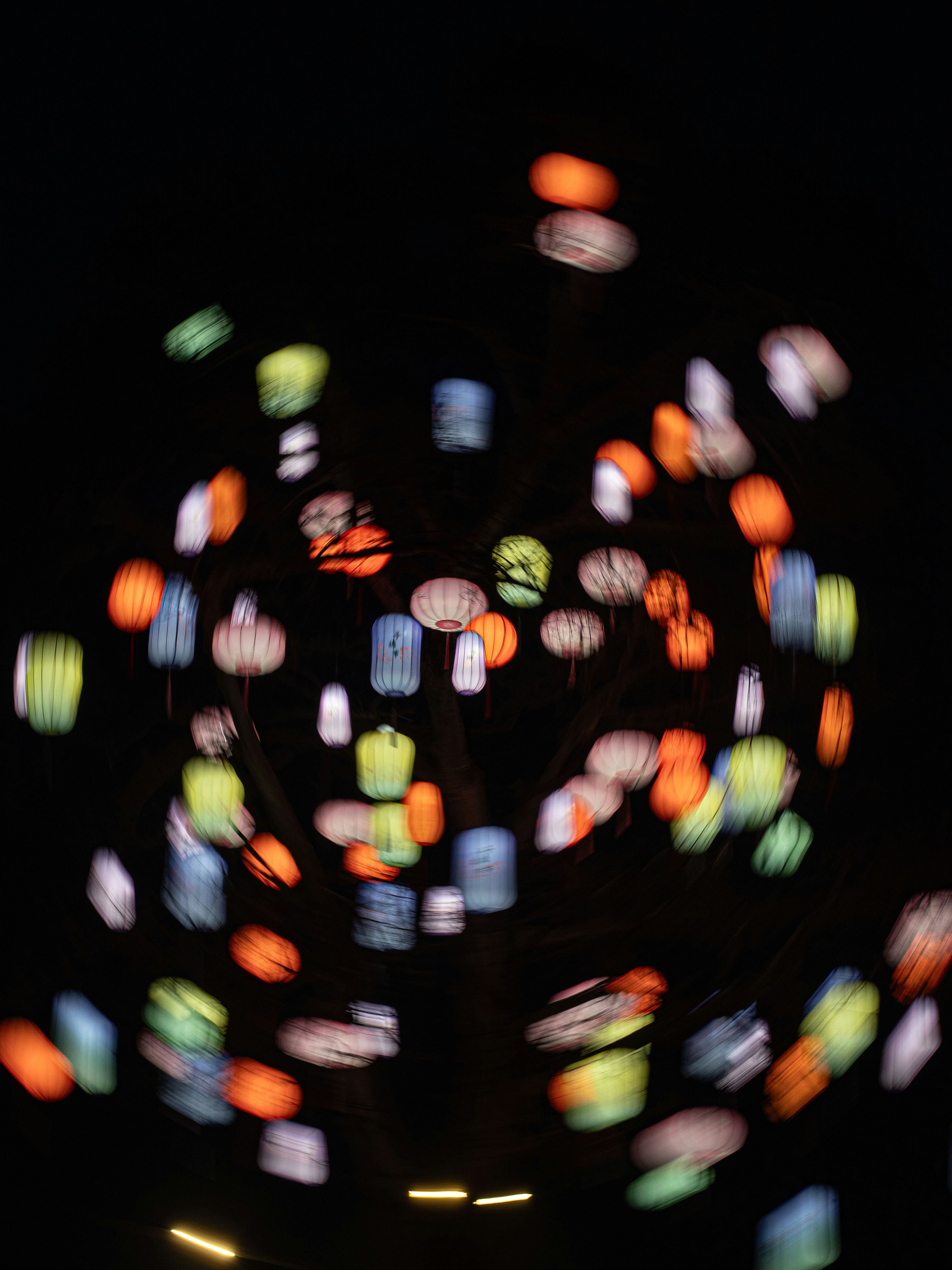 Colorful lanterns floating in the dark night sky.