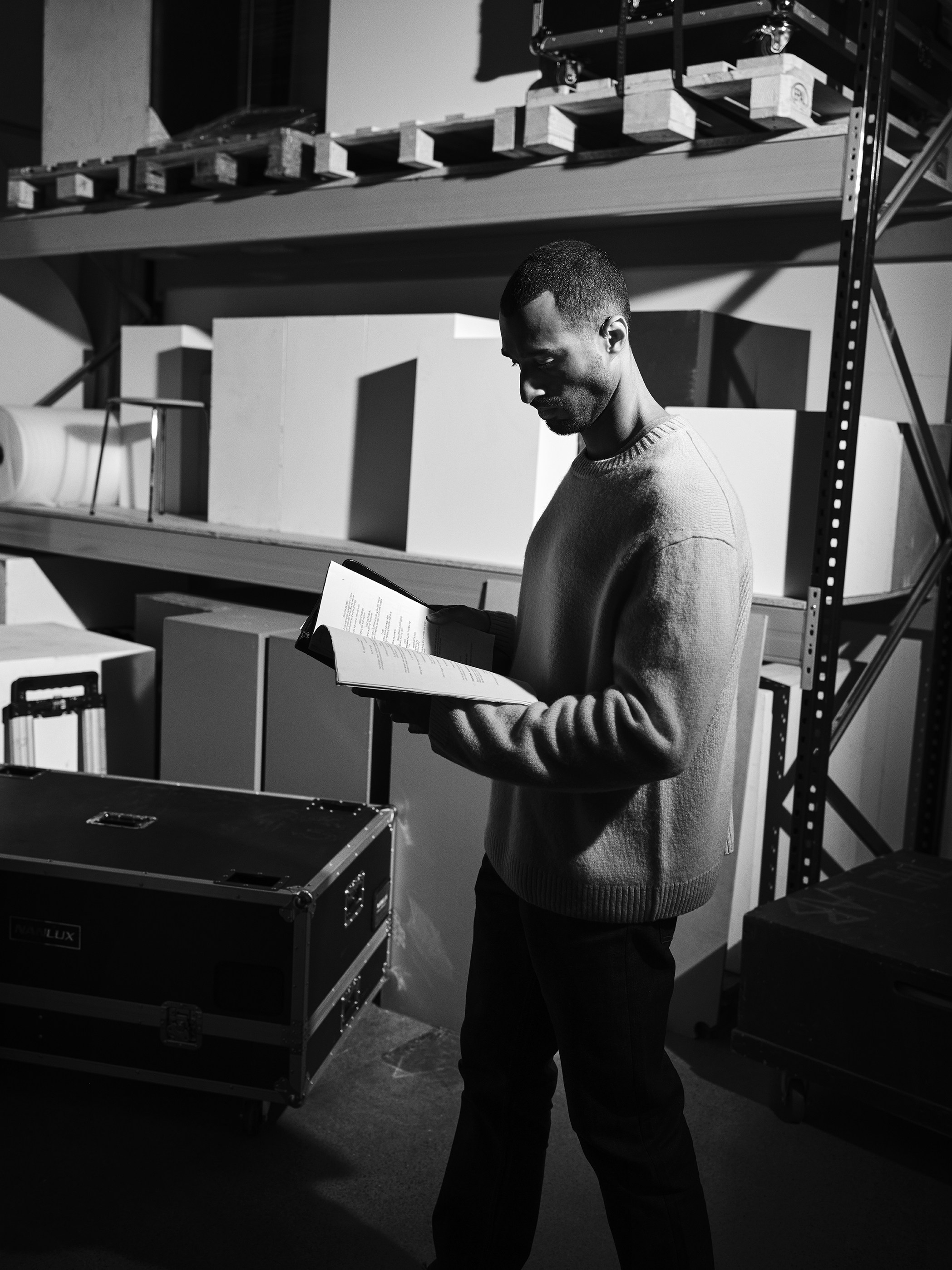 Reader in the Warehouse Light: A Quiet Moment with a Script