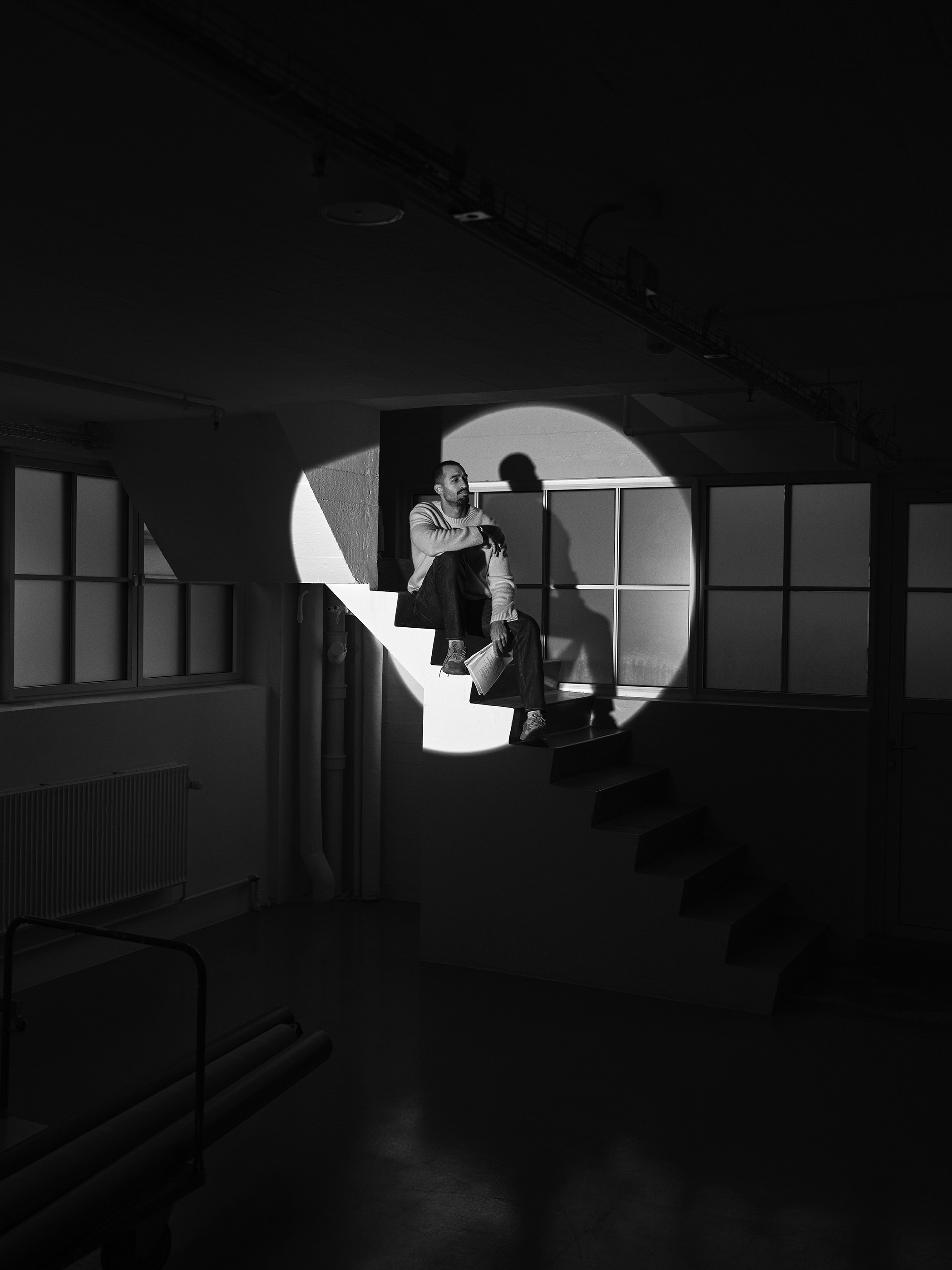 Spotlit Quiet: A Man in Shadow on the Staircase